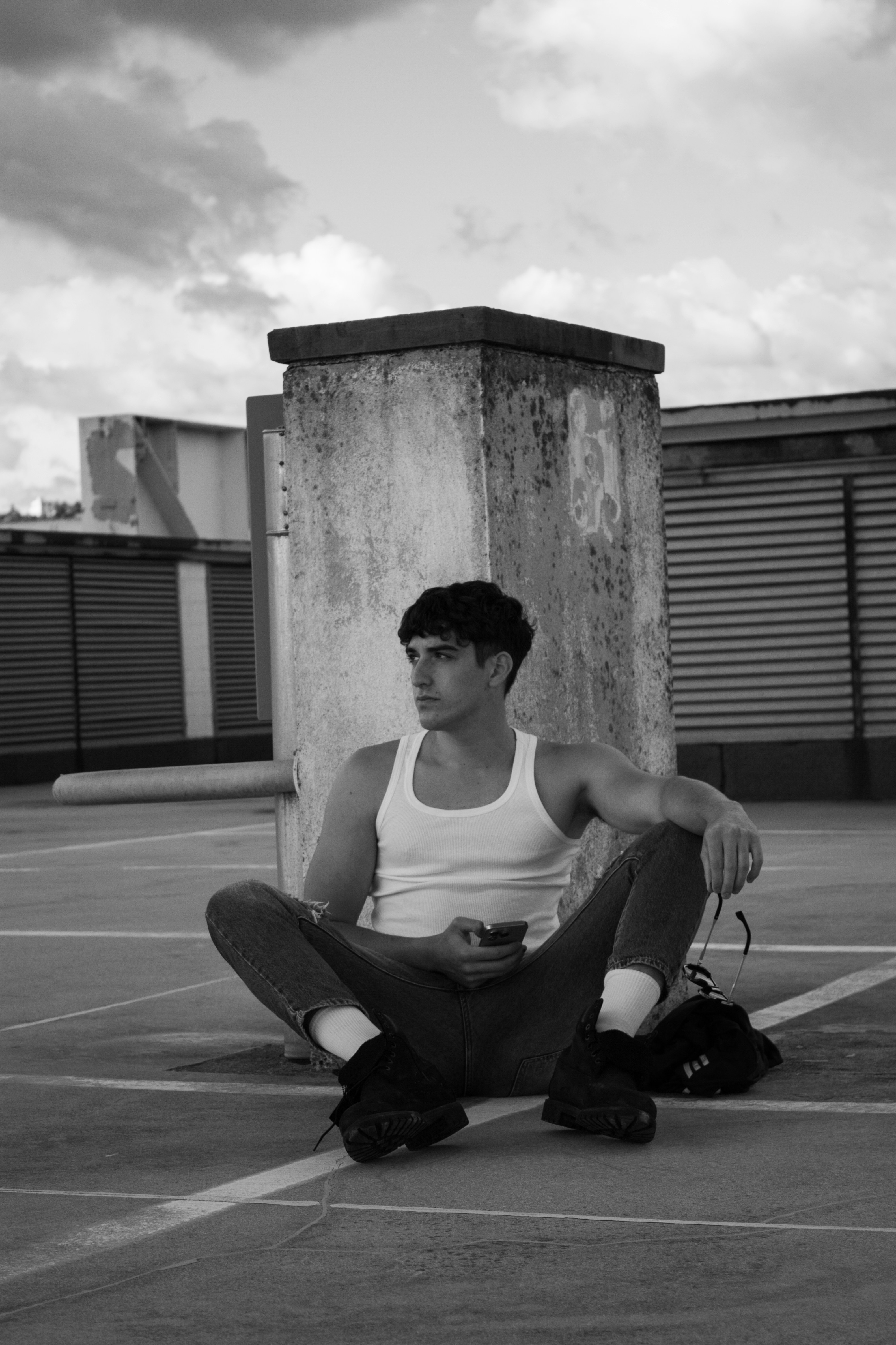 Rooftop Quiet: A contemplative portrait against weathered concrete