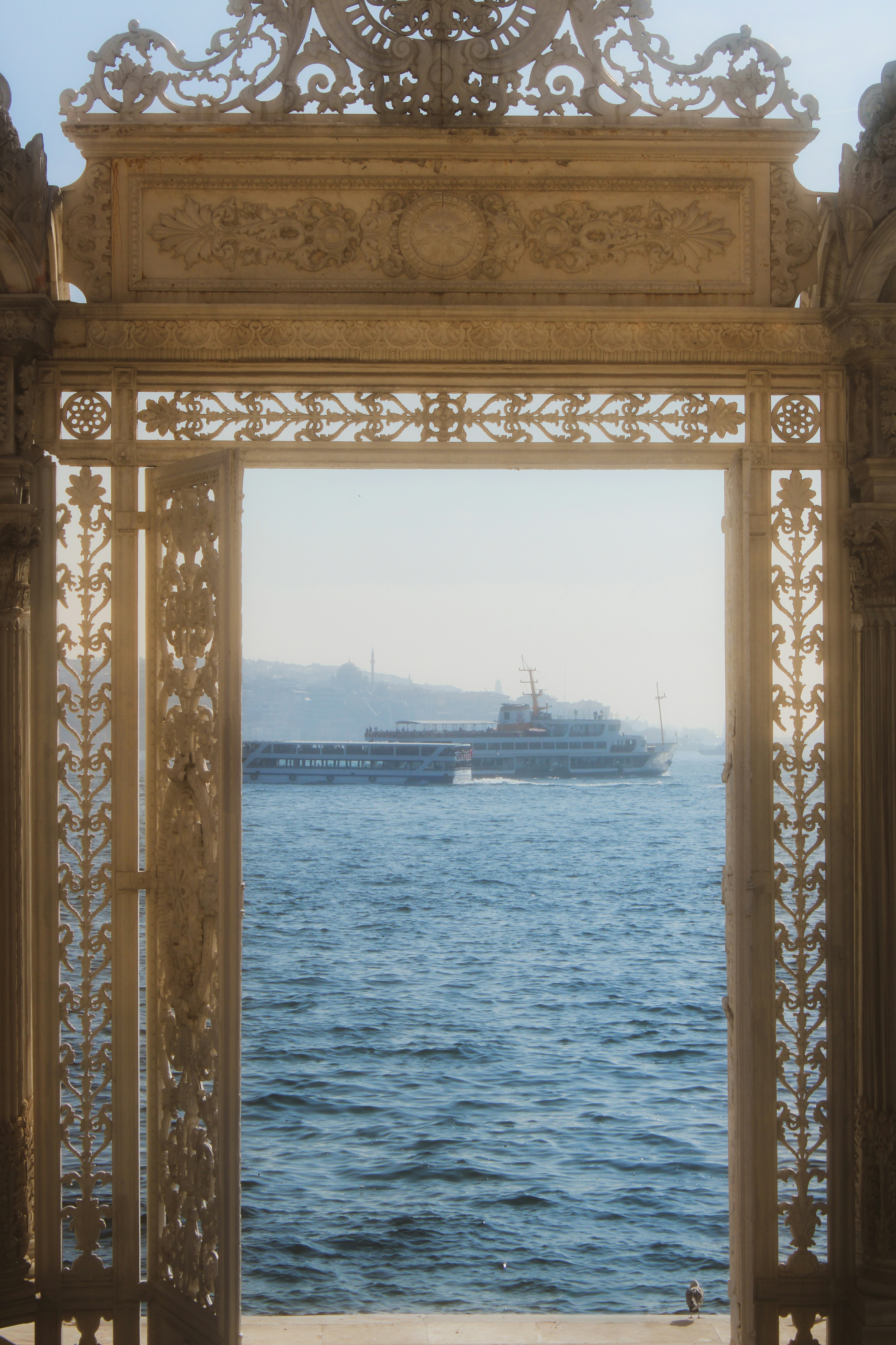 Ornate Threshold Framing a Sunlit Ferry Across Calm Waters