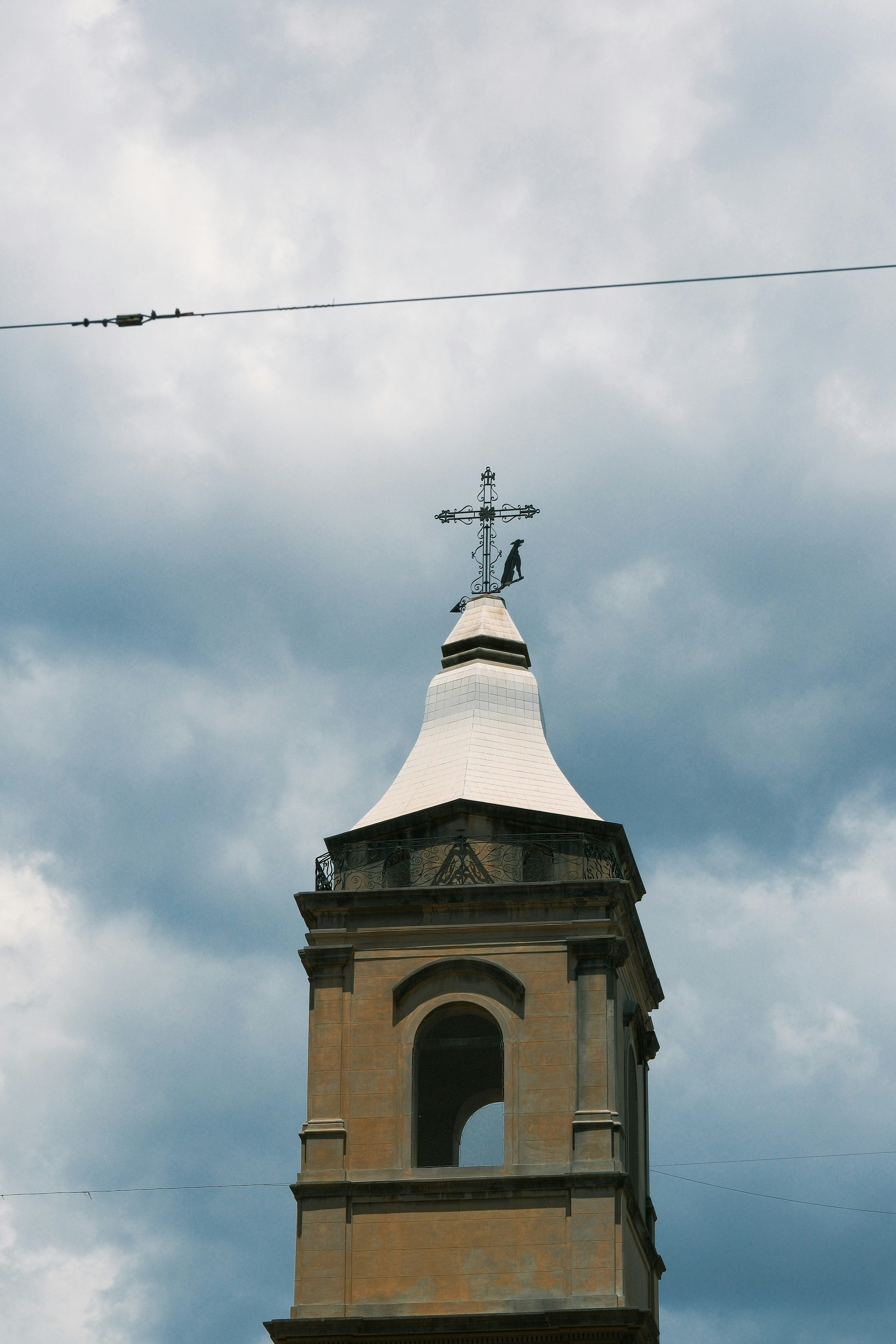 Silvery Spire: A Historic Bell Tower Reaching Toward a Clouded Sky