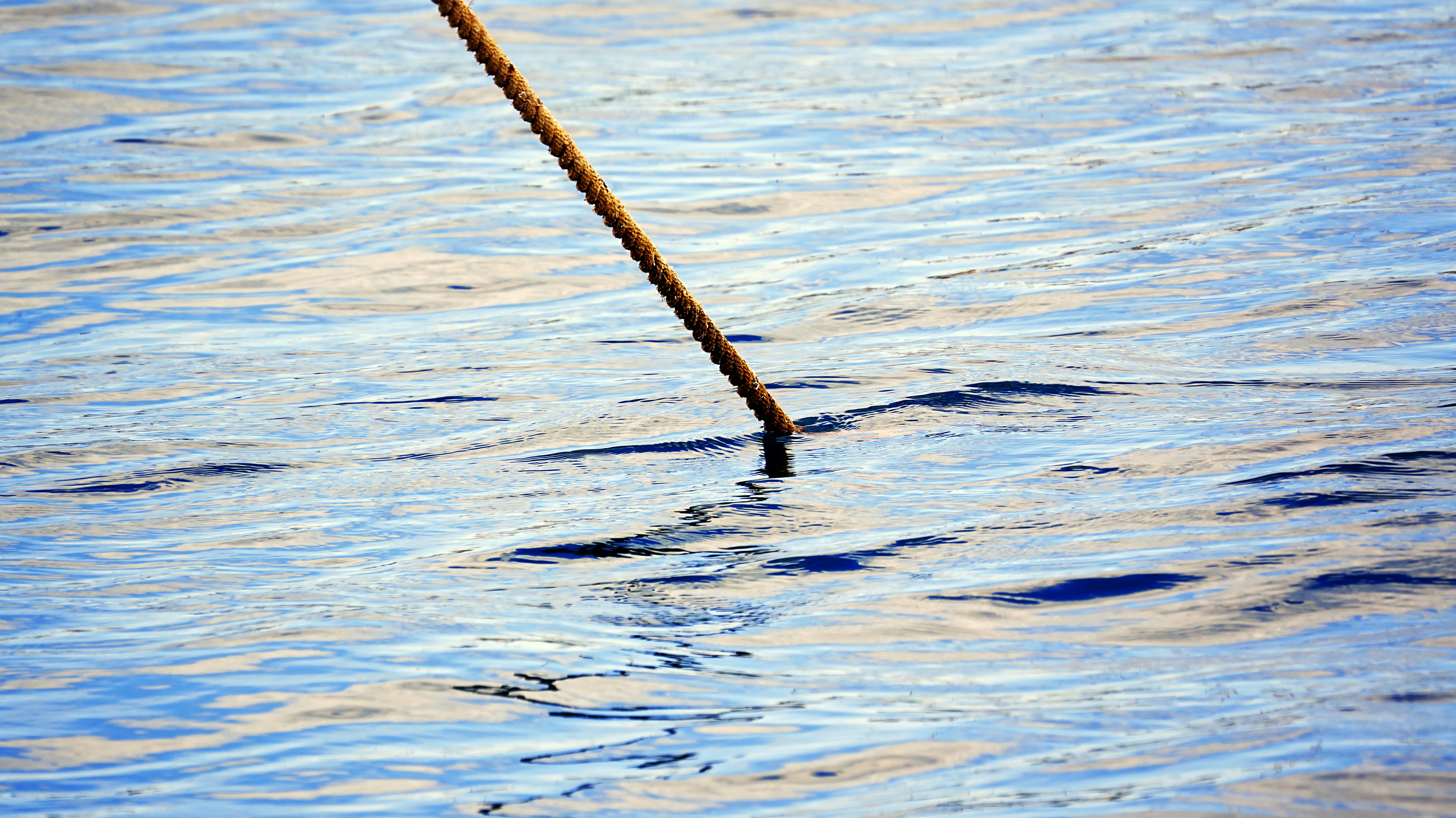 Diagonal Rope Across Quiet Blue Reflections