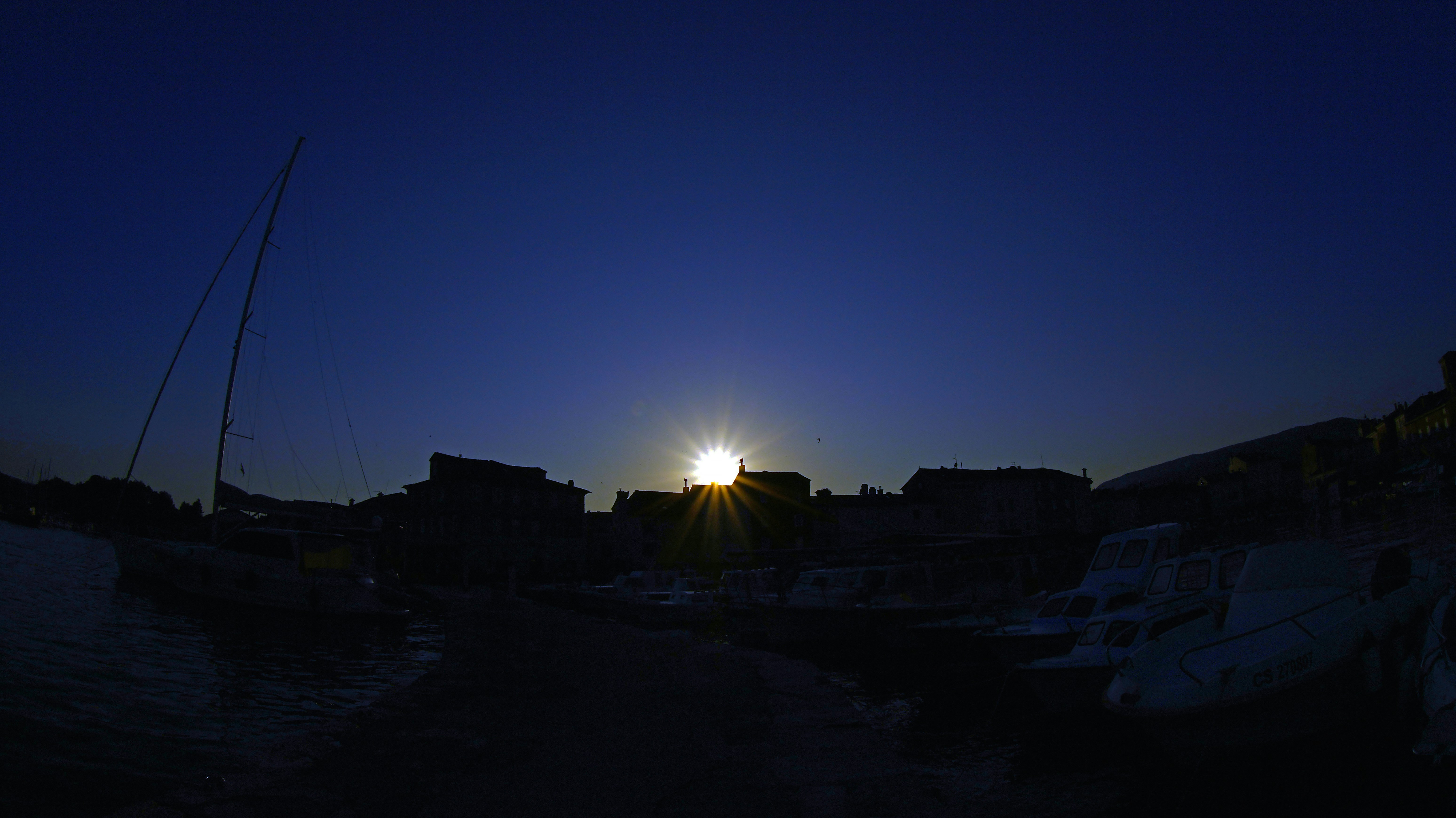 Blue Hour Sunburst Over a Quiet Marina
