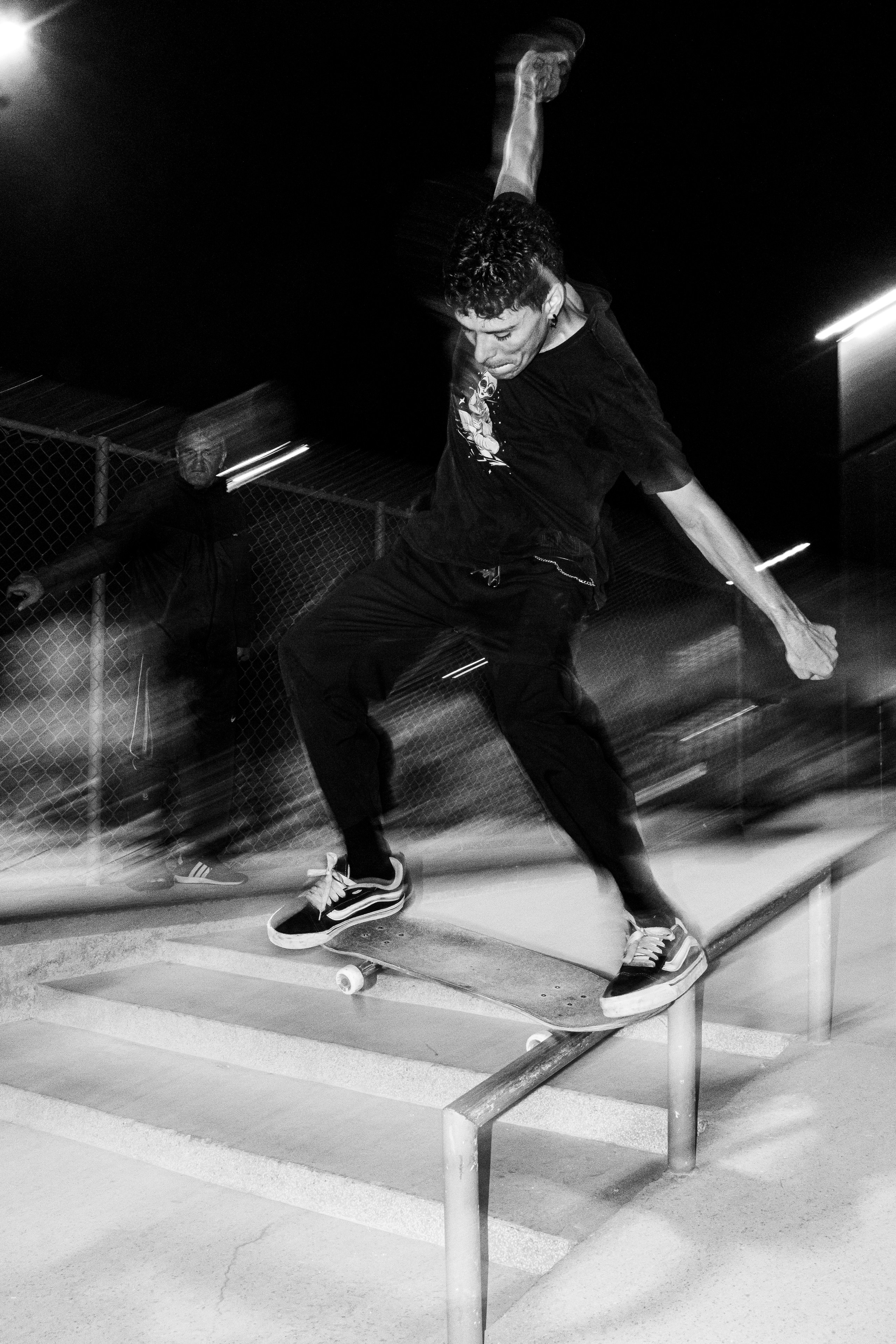 Night skateboarding grind; motion blur captures raw urban energy and intense focus.