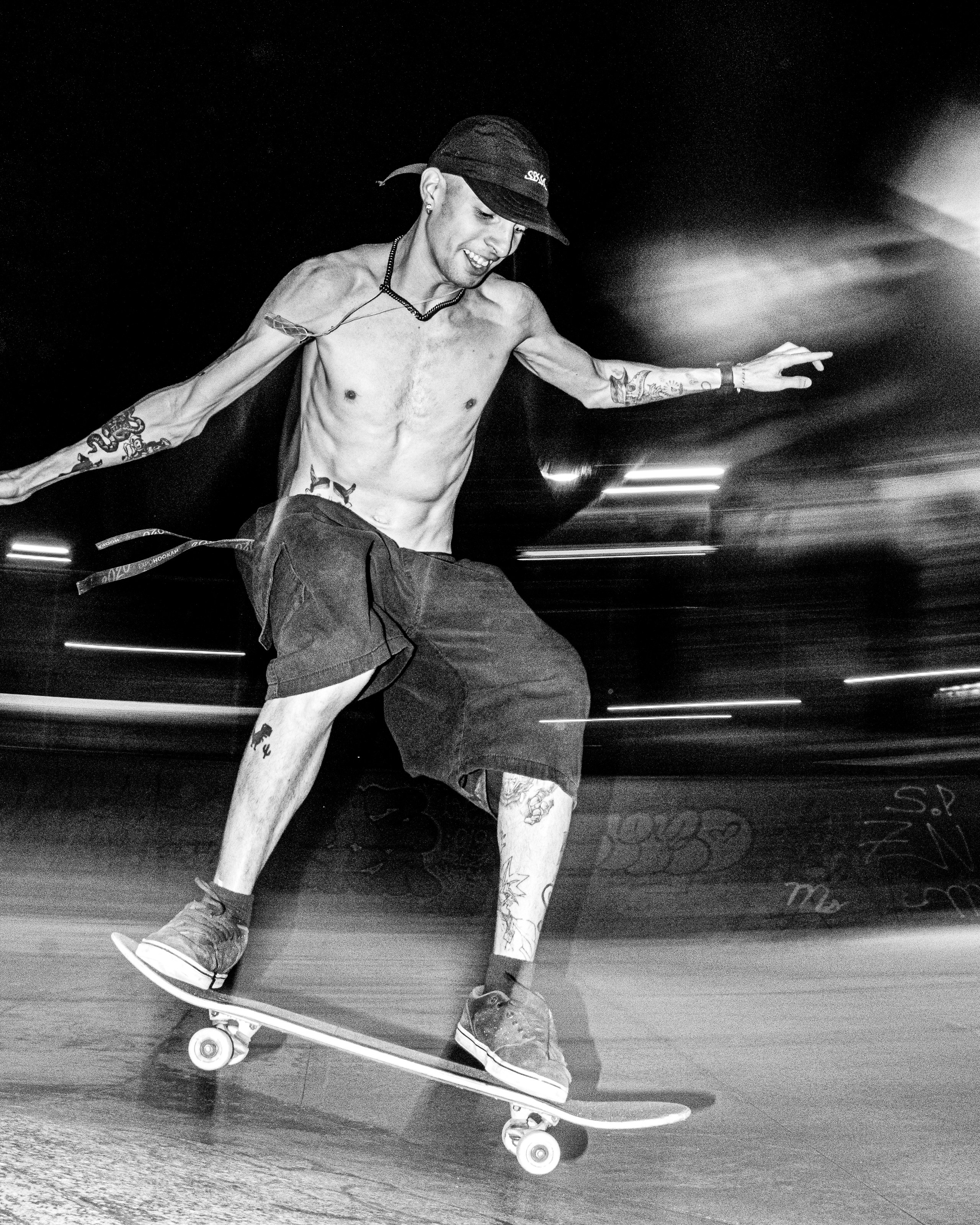 Joyful skateboarder blurs through the night, a raw urban spirit.