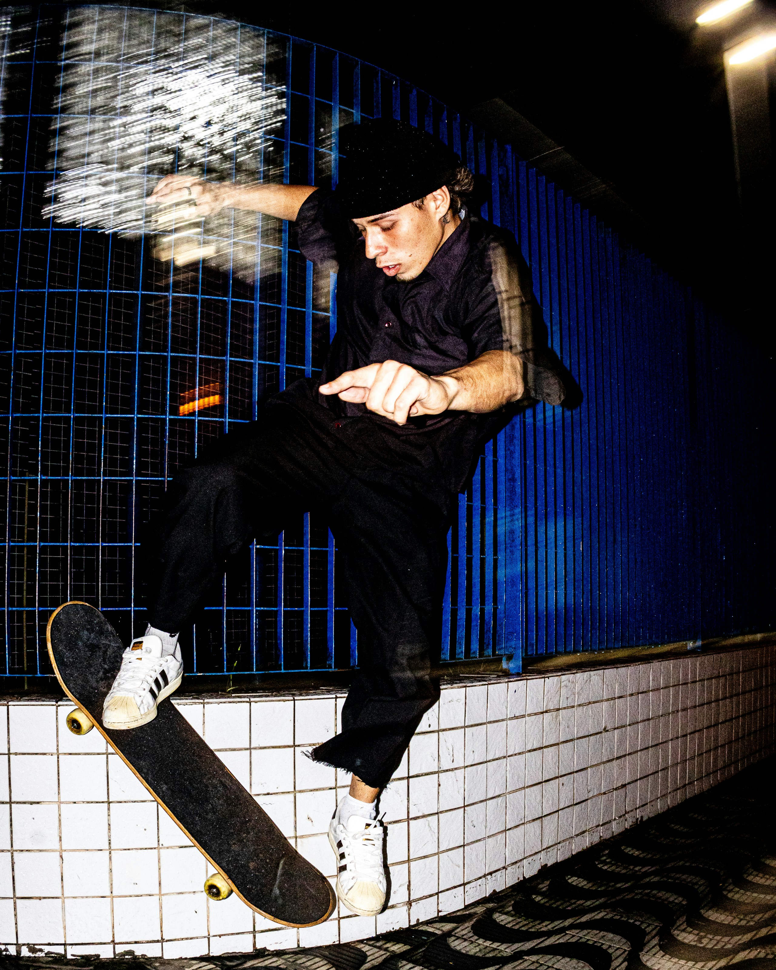 Midnight Kickflip Along a Blue Fence