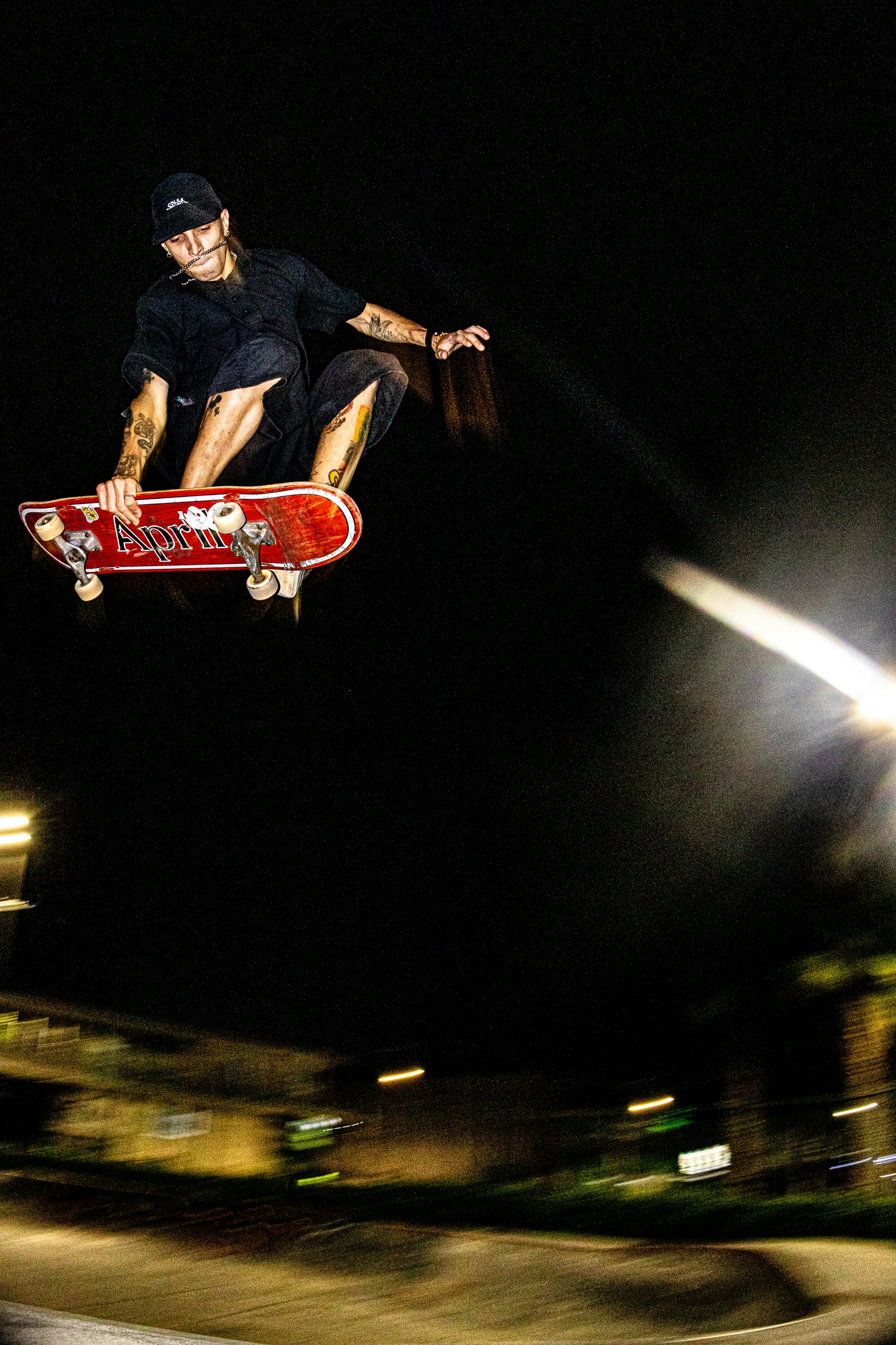 Night skater defies gravity, red board glowing, tattooed arms, urban rebellion.