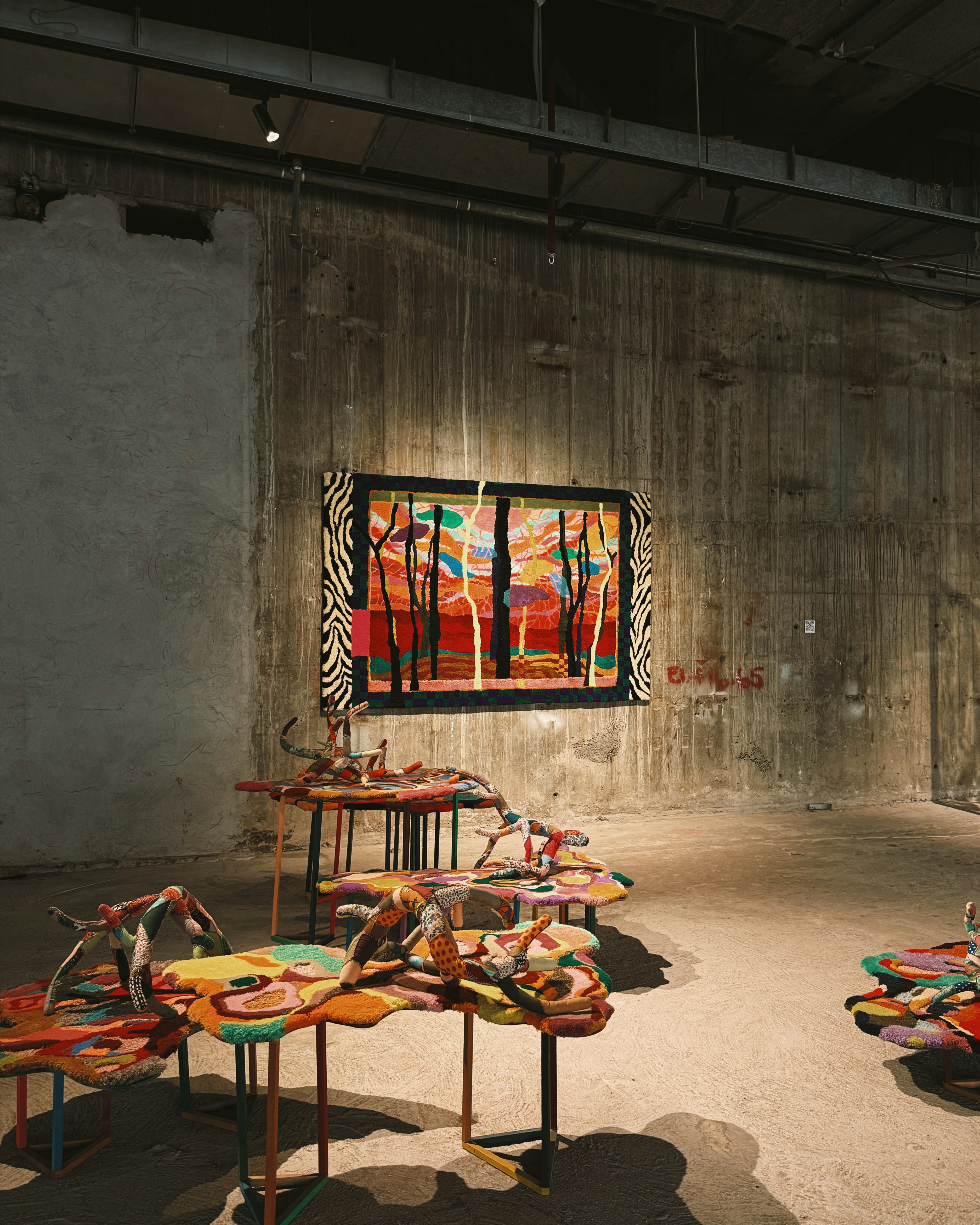 Forest on Concrete: Painted Trees and Textile Sculptures in a Dim Gallery
