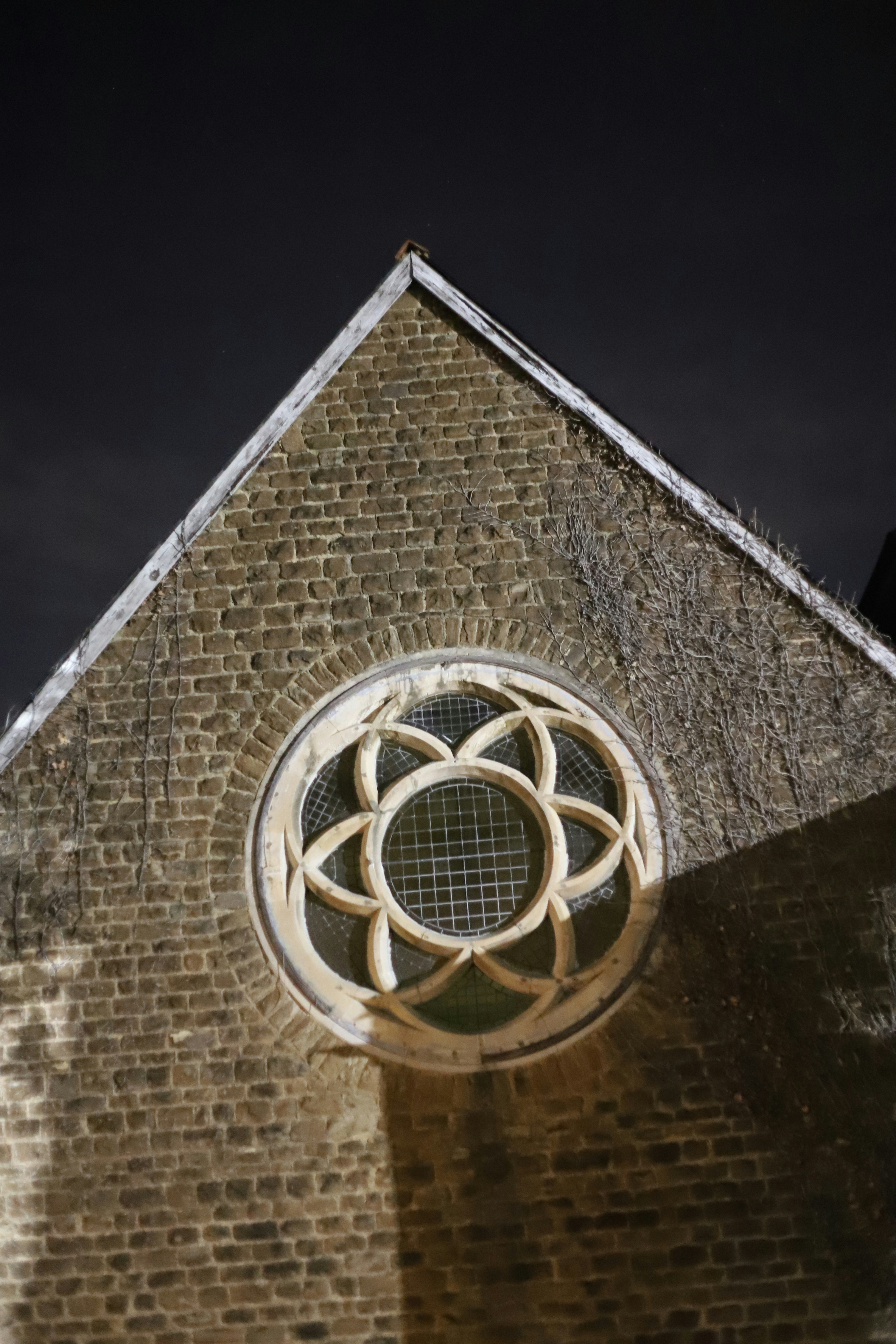 Rosette at Midnight: Snow-Kissed Brick Church Under a Starry Sky