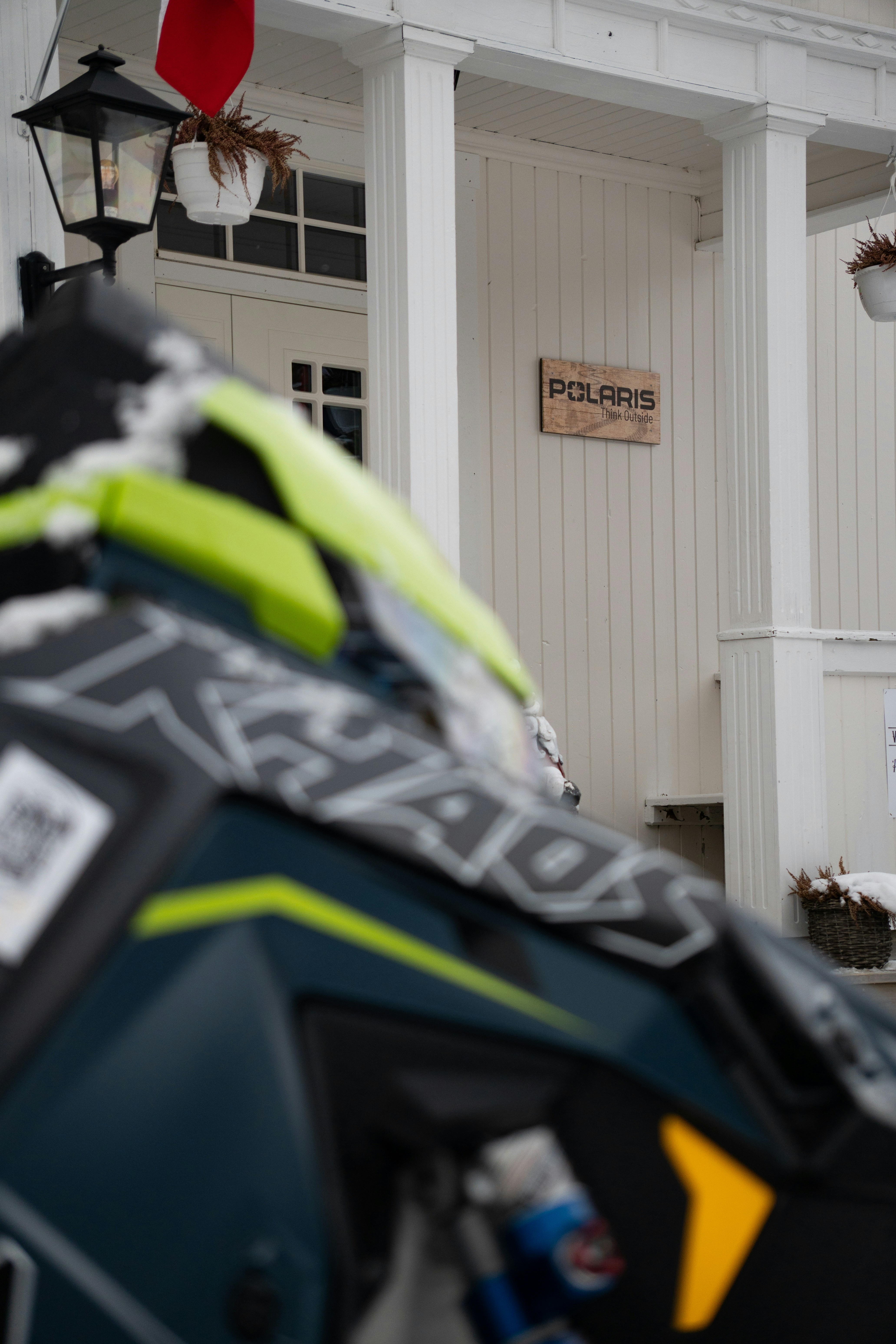 Polaris on a Snow-White Porch, Framed by a Neon-Highlighted Snowmobile
