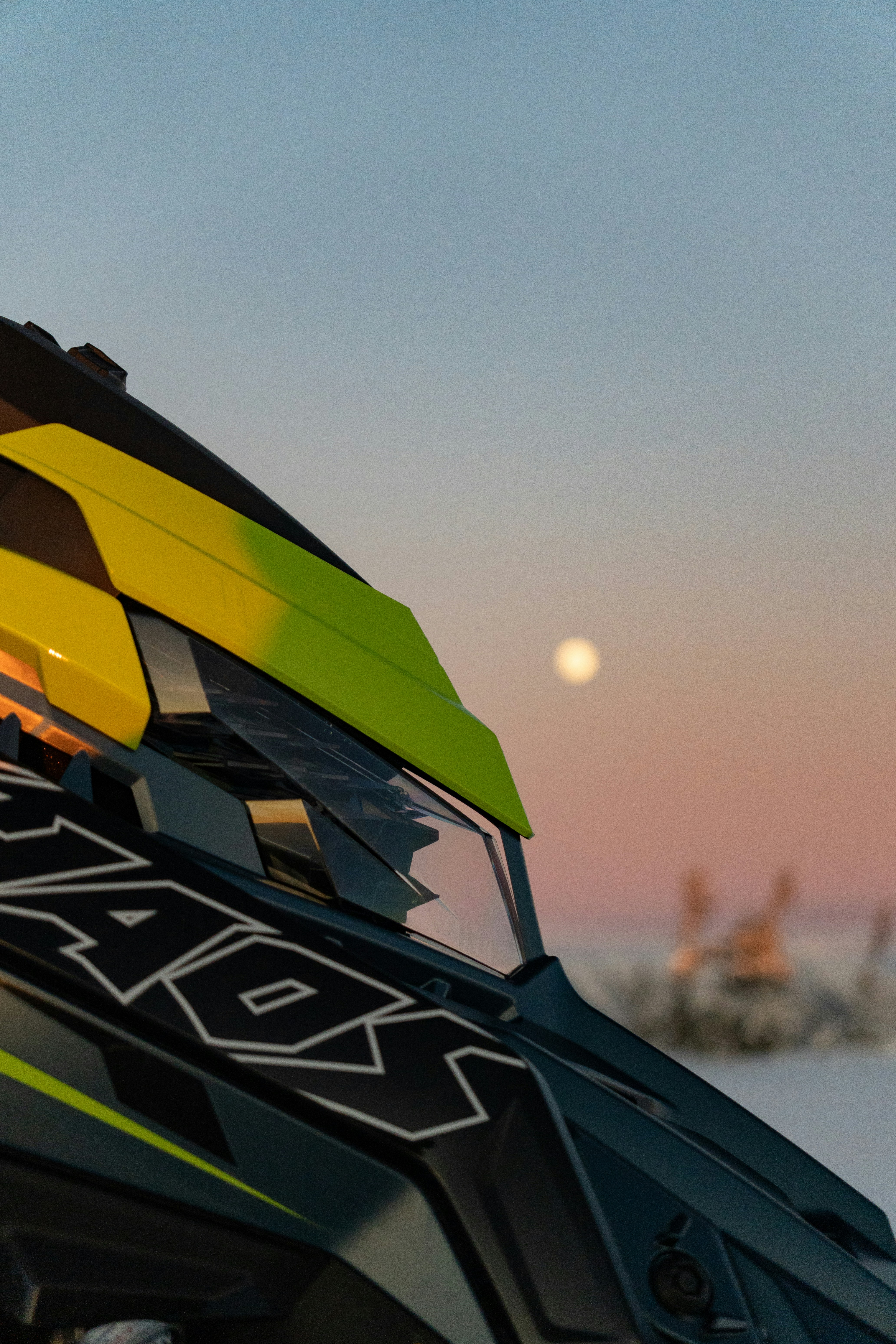 Snowmobile headlight with moon in pastel sky