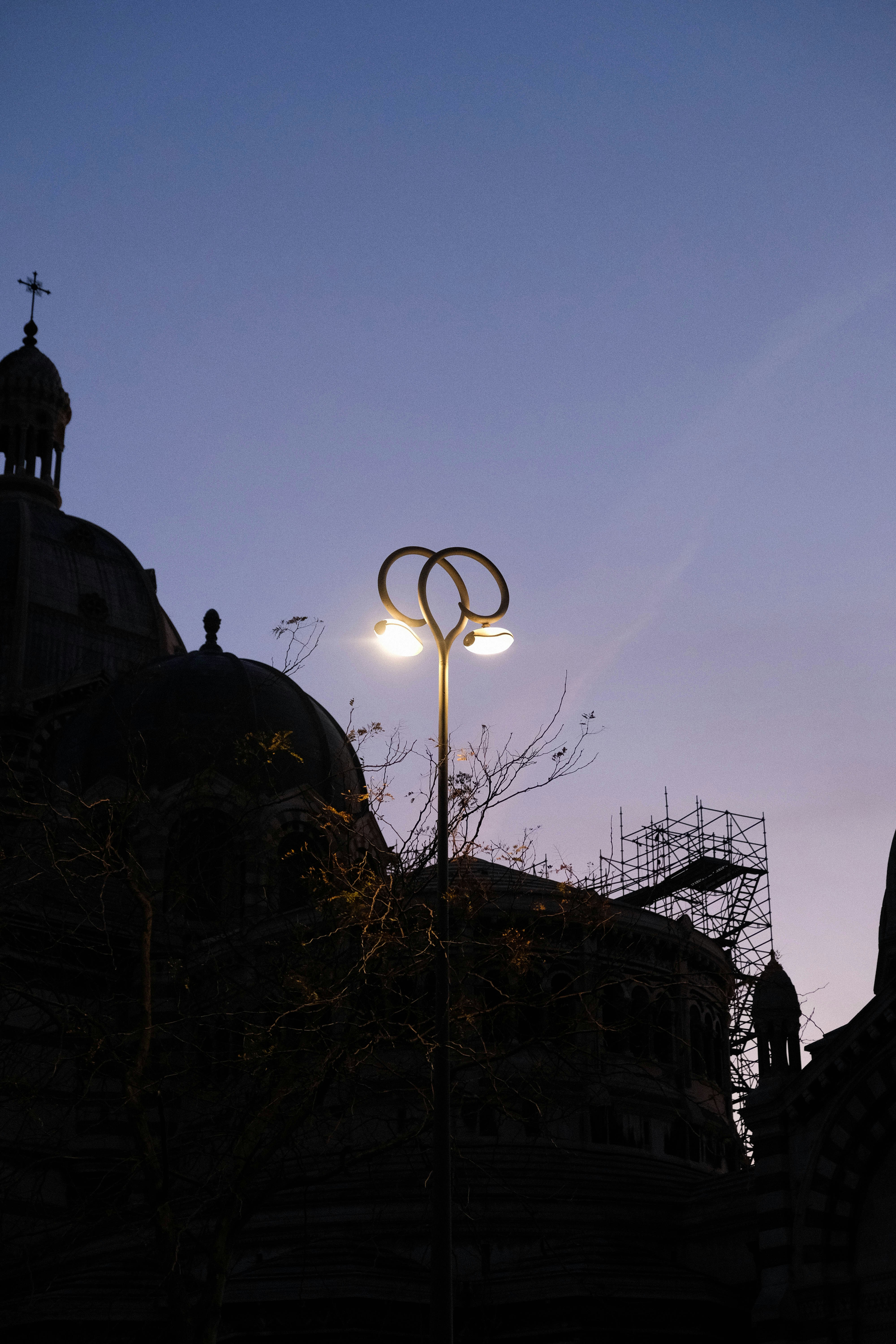 Twinned-loop Lamppost at Dusk: Light Between a Cathedral Silhouette and Scaffold