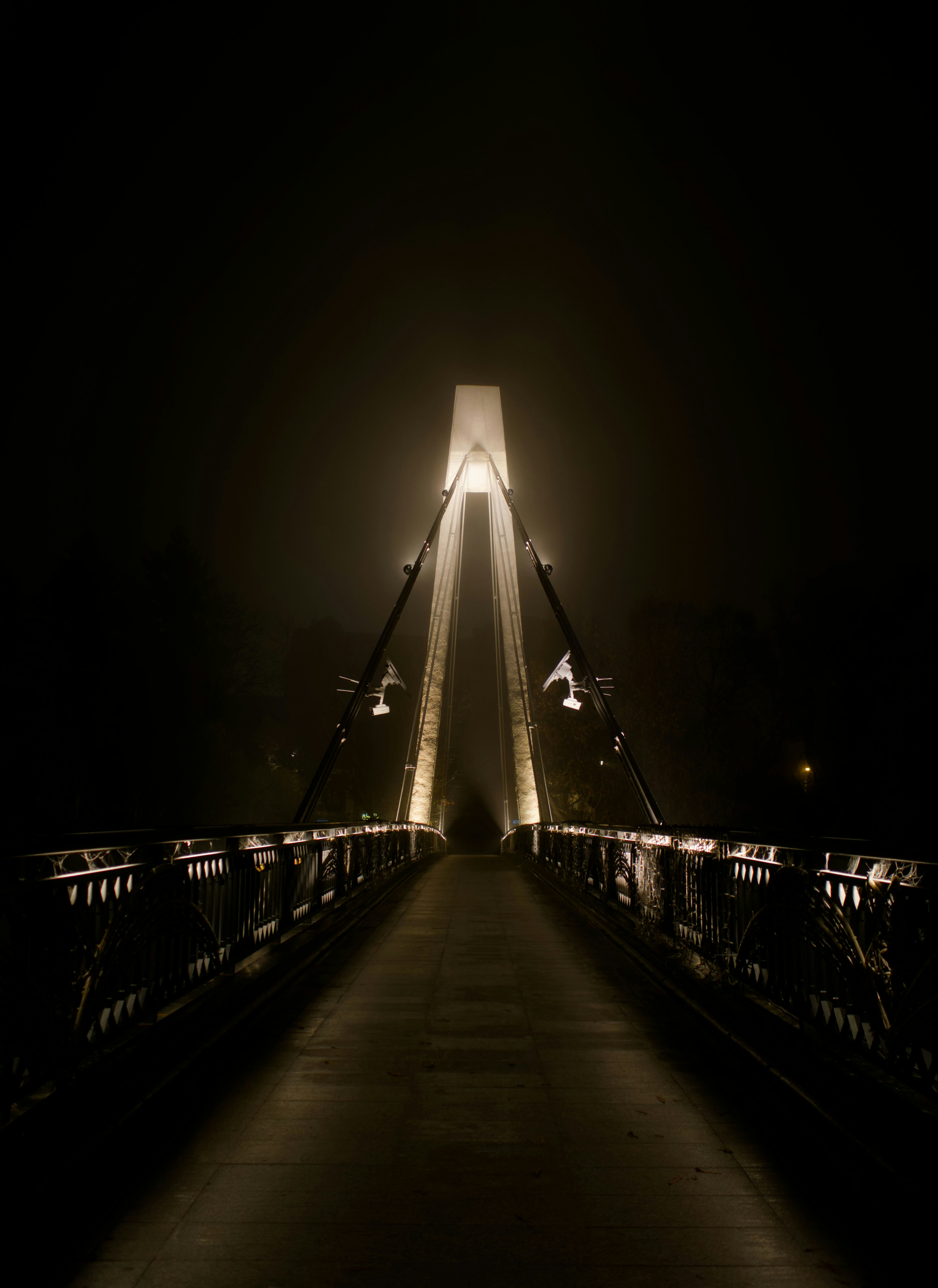Luminescent Ascent: Night Suspension Bridge Pierces the Mist