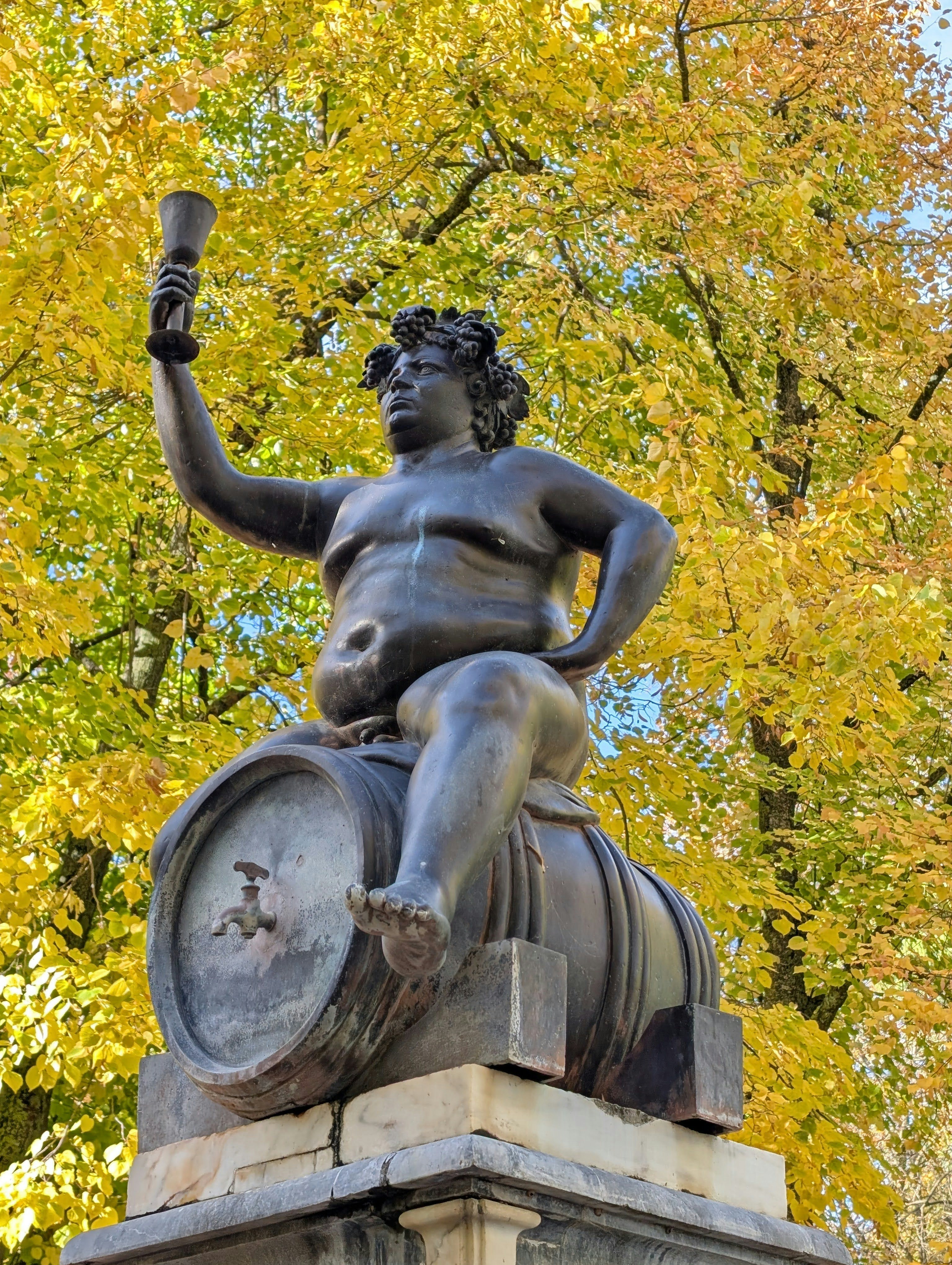 Autumn-Glow Bronze Titan Perched on a Barrel
