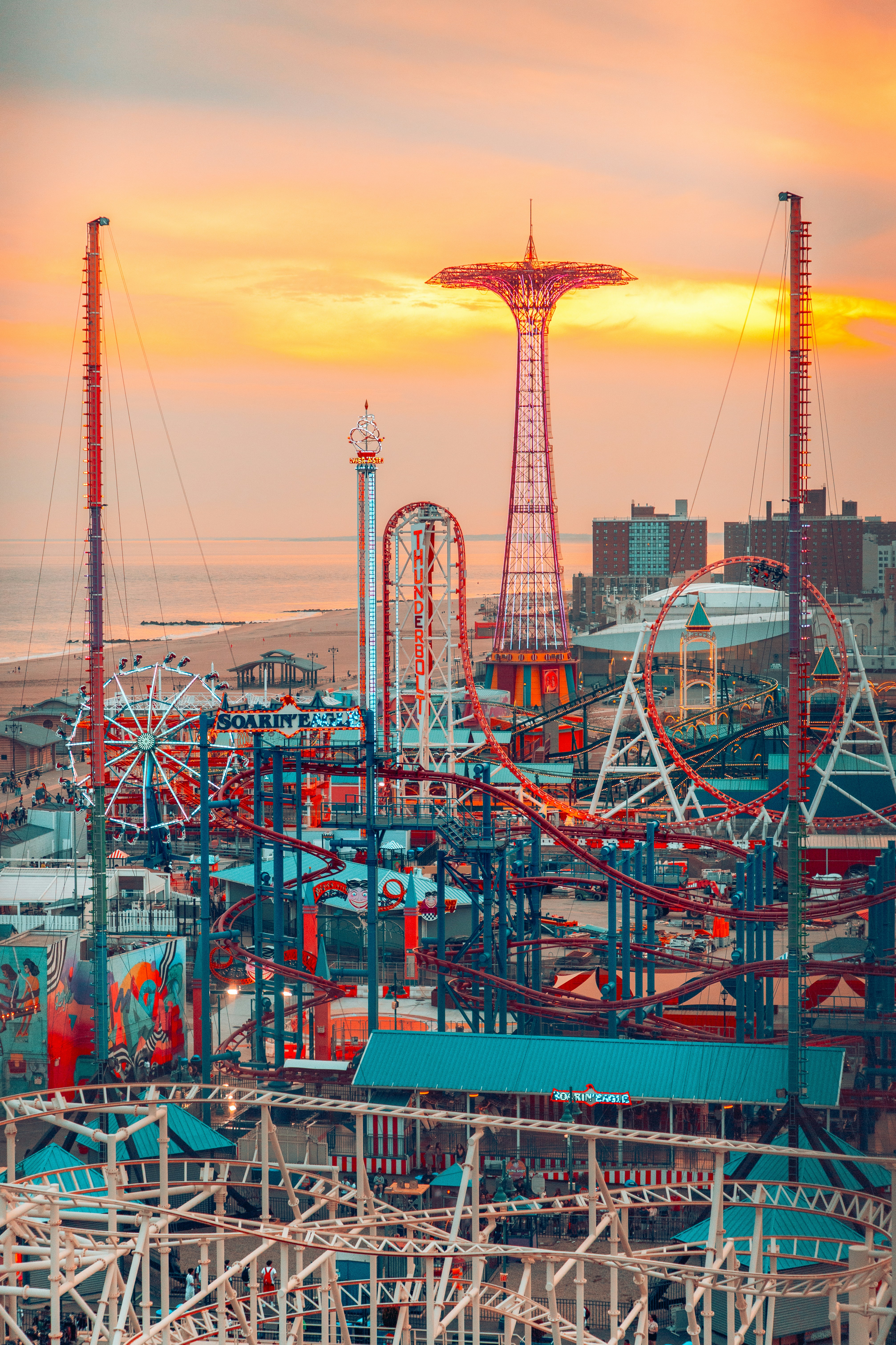 Amusement park rides against a sunset sky