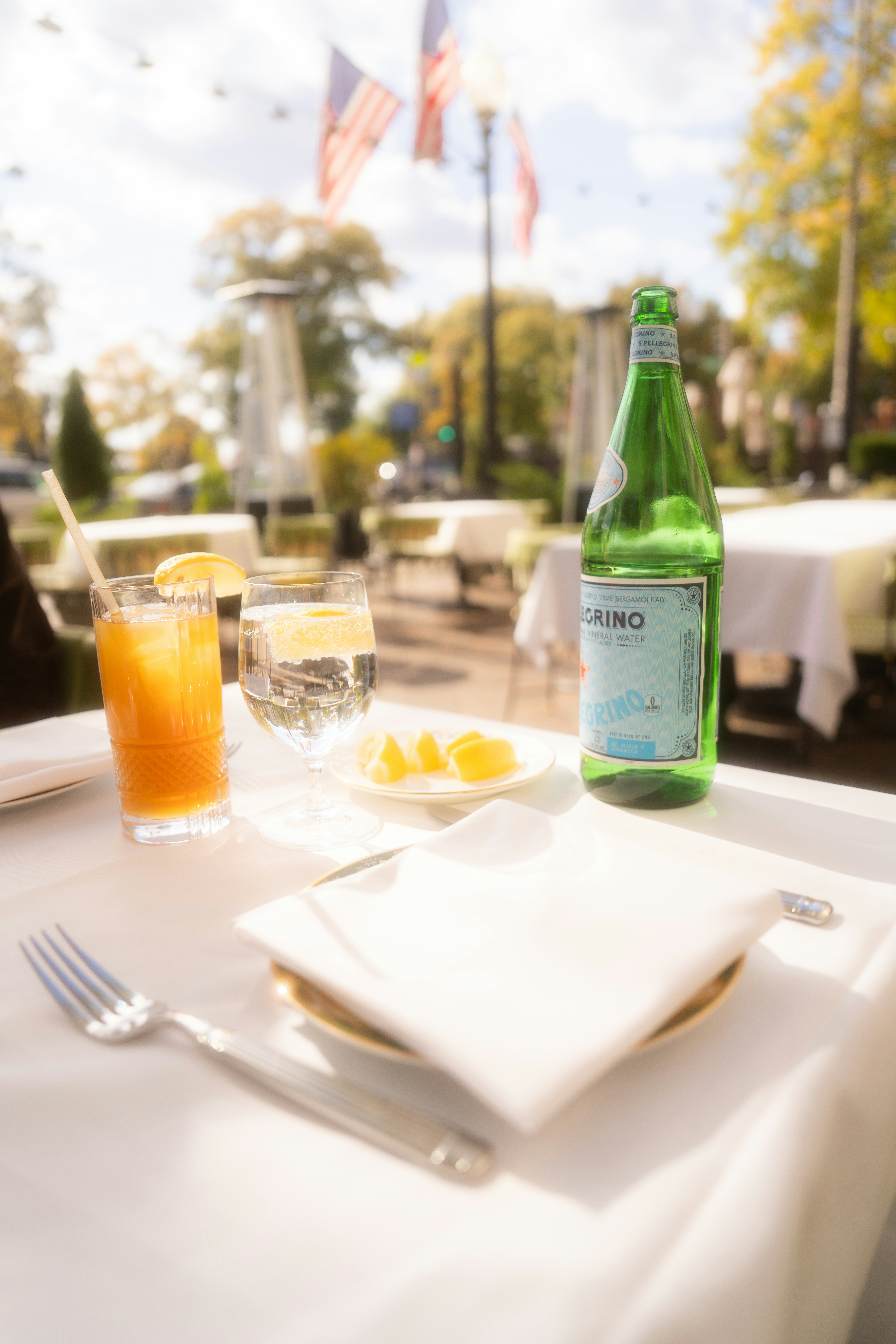 Brunch at the Plaza: A Green Sparkling Bottle Anchors a Sunlit Table