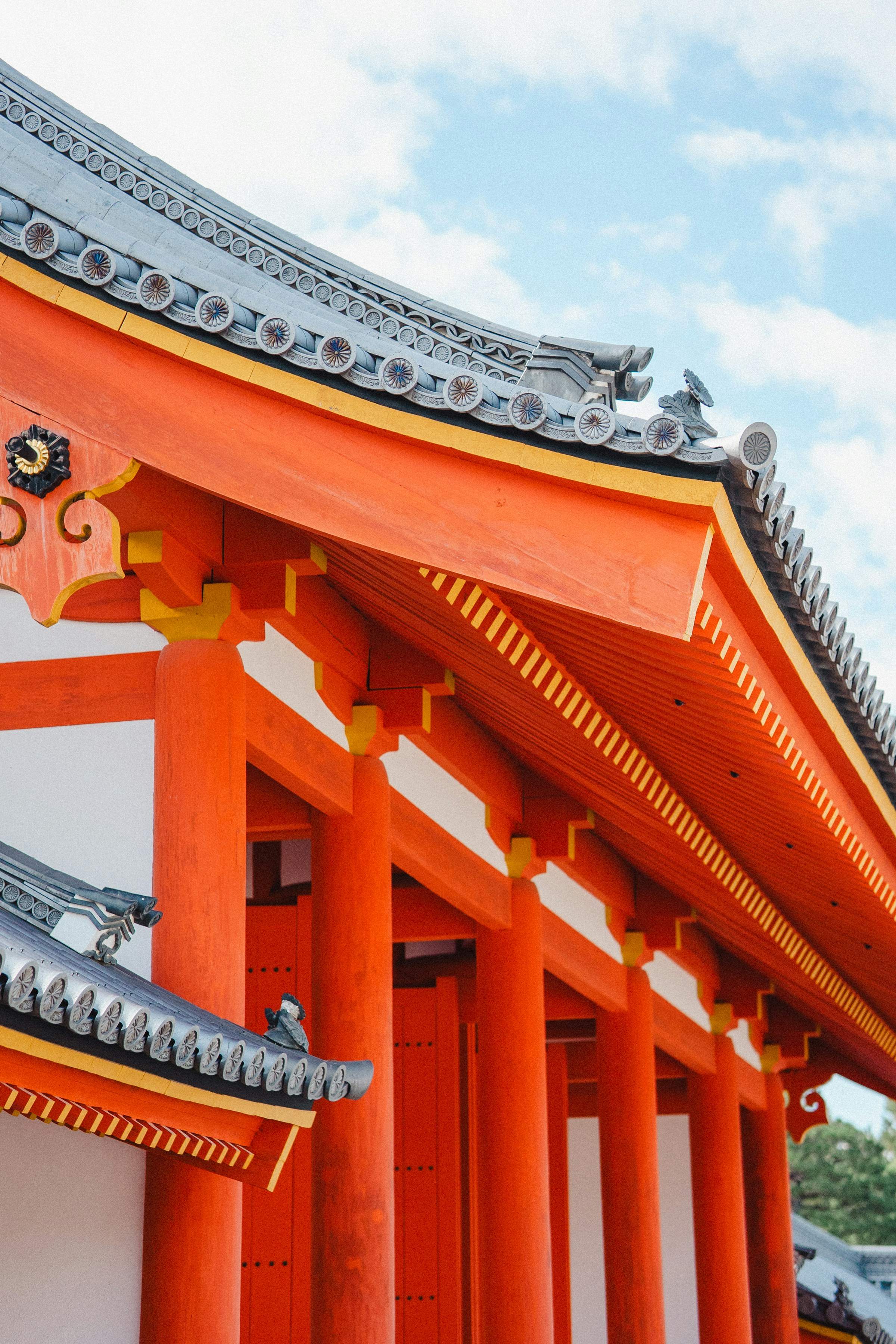 Bright vermilion pillars and curved rooflines of a Japanese temple against the sky