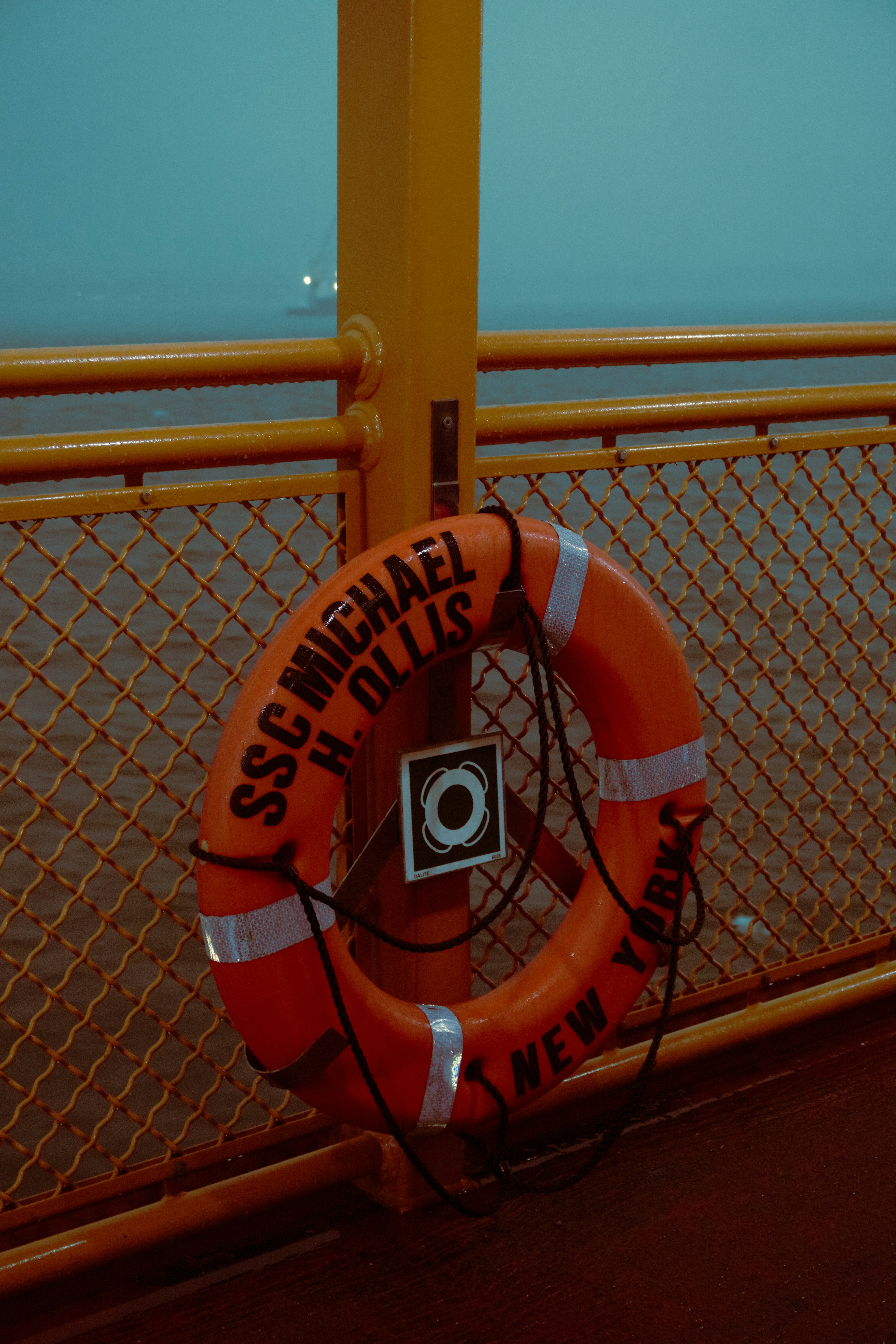 Lifebuoy on a Pier Railing: Neon Orange Beacon Against Turquoise Sea