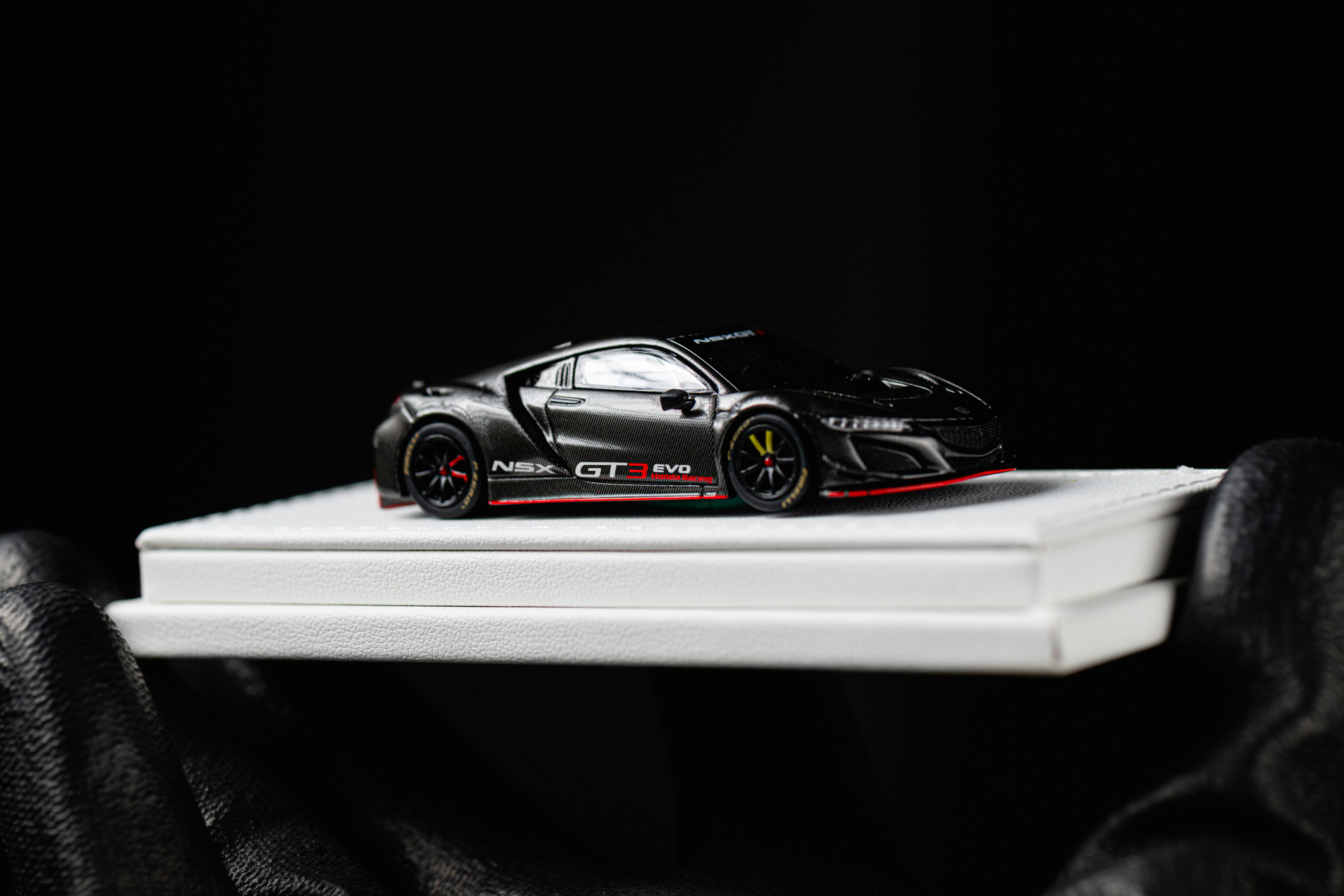 Tiny Racer on a White Stage: A Macro Still-Life of a Black Model Car