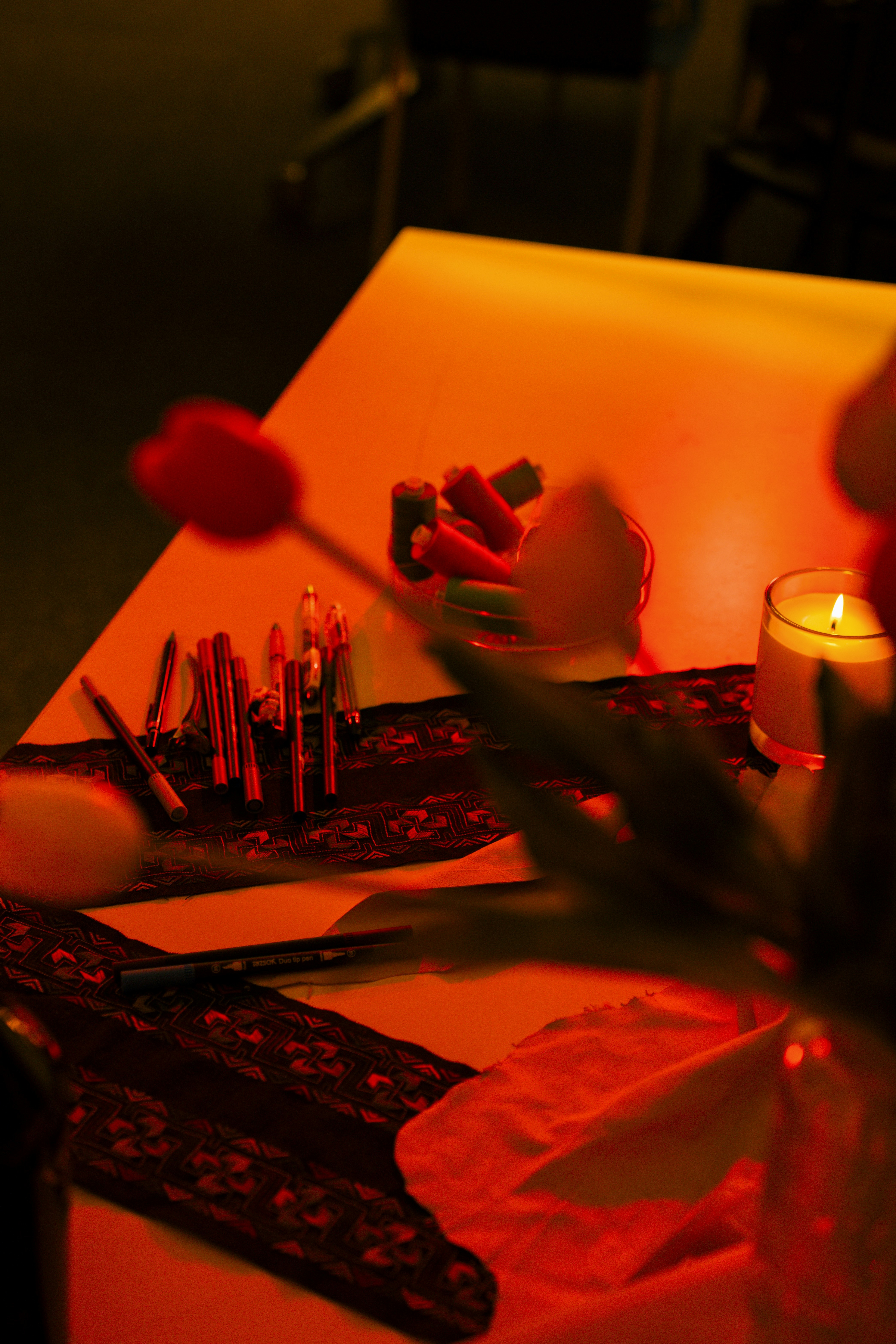 Candlelit Couture: A Table of Makeup Tools in Ember Light