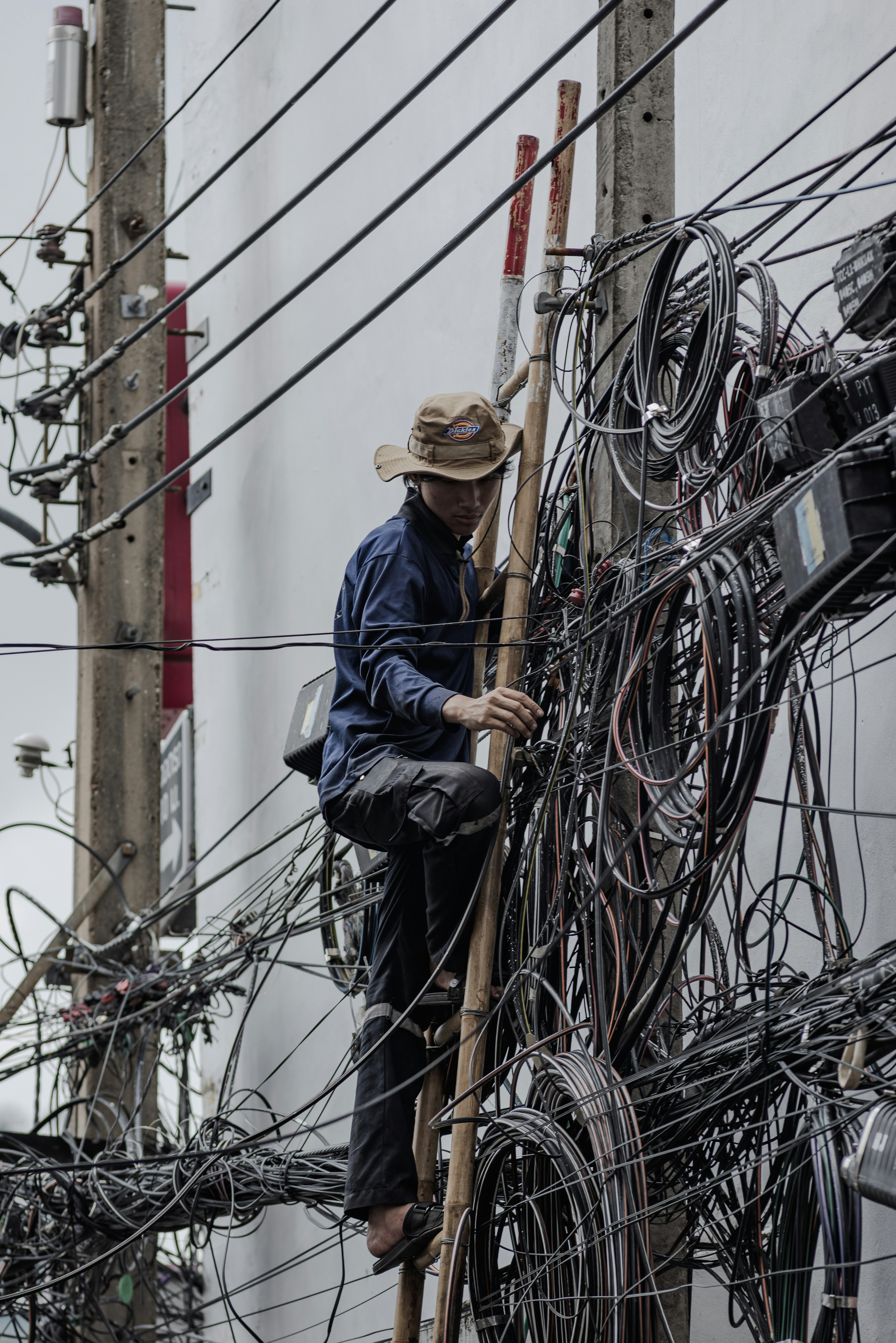 Man climbs utility pole with many tangled wires photo – Free Risk Image ...