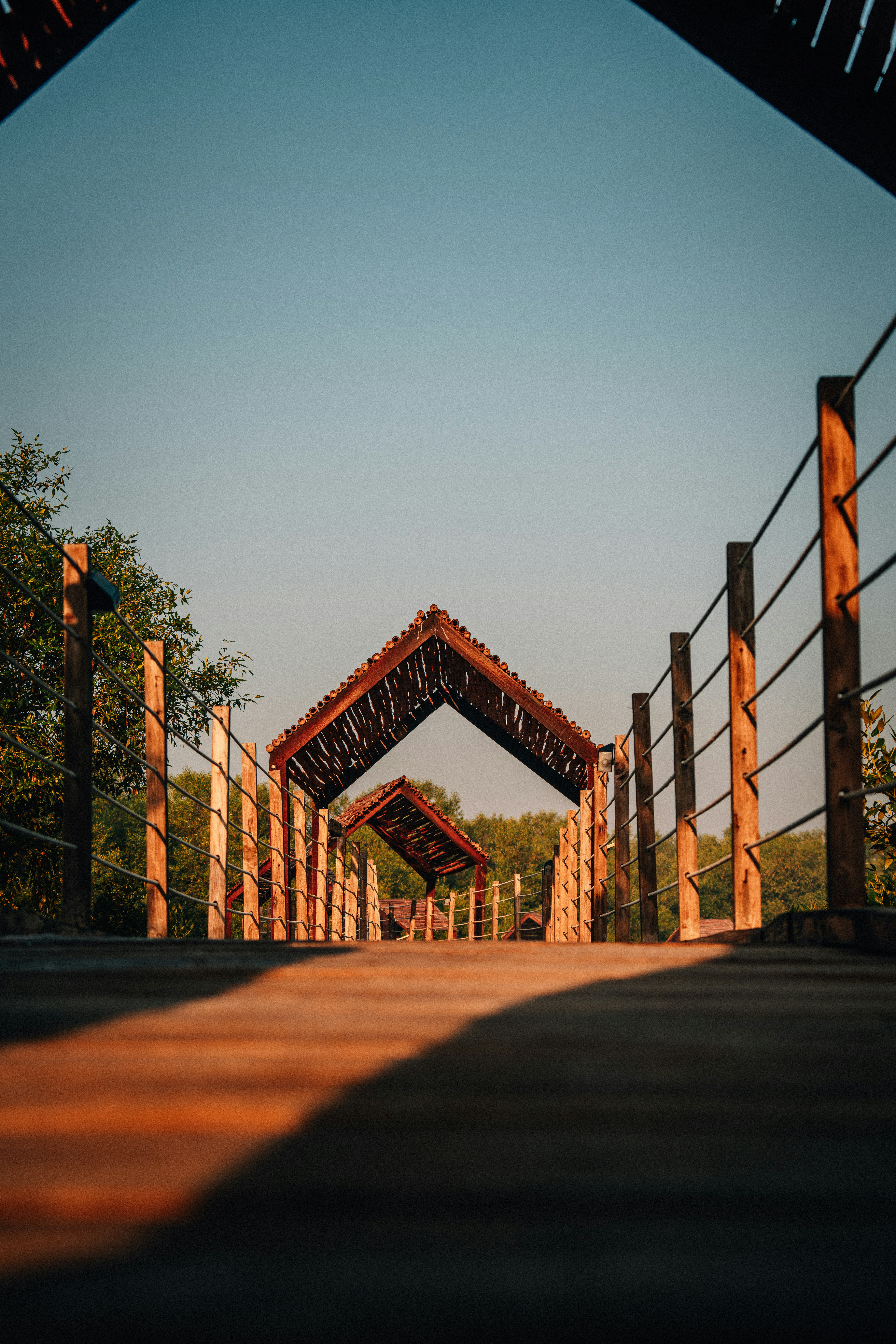 Golden Timber Arches: A Quiet Boardwalk Receding into Dusk