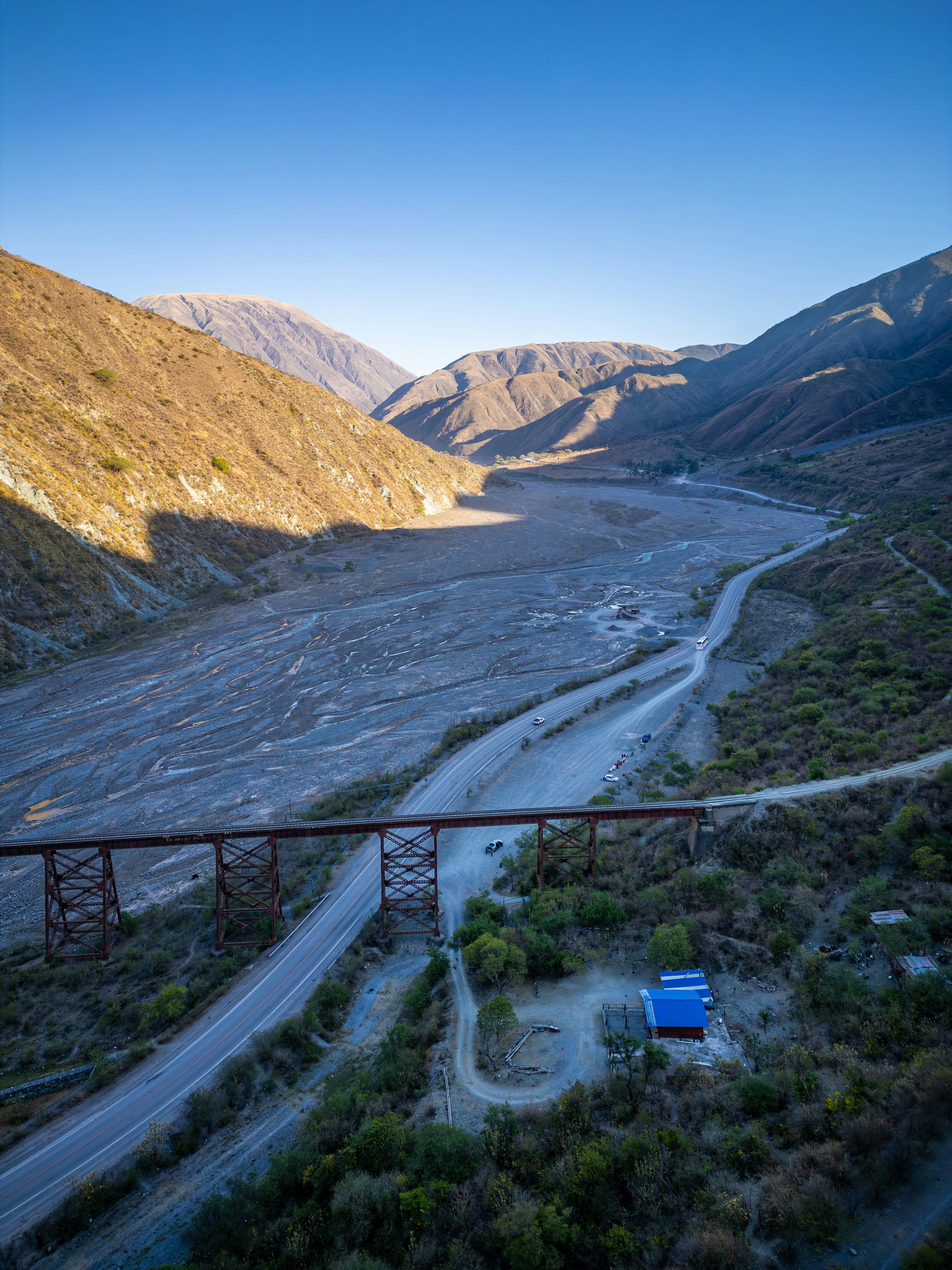Rusted Span Over the Dry River Gorge: A Drone's Eye View of Desert Valleys