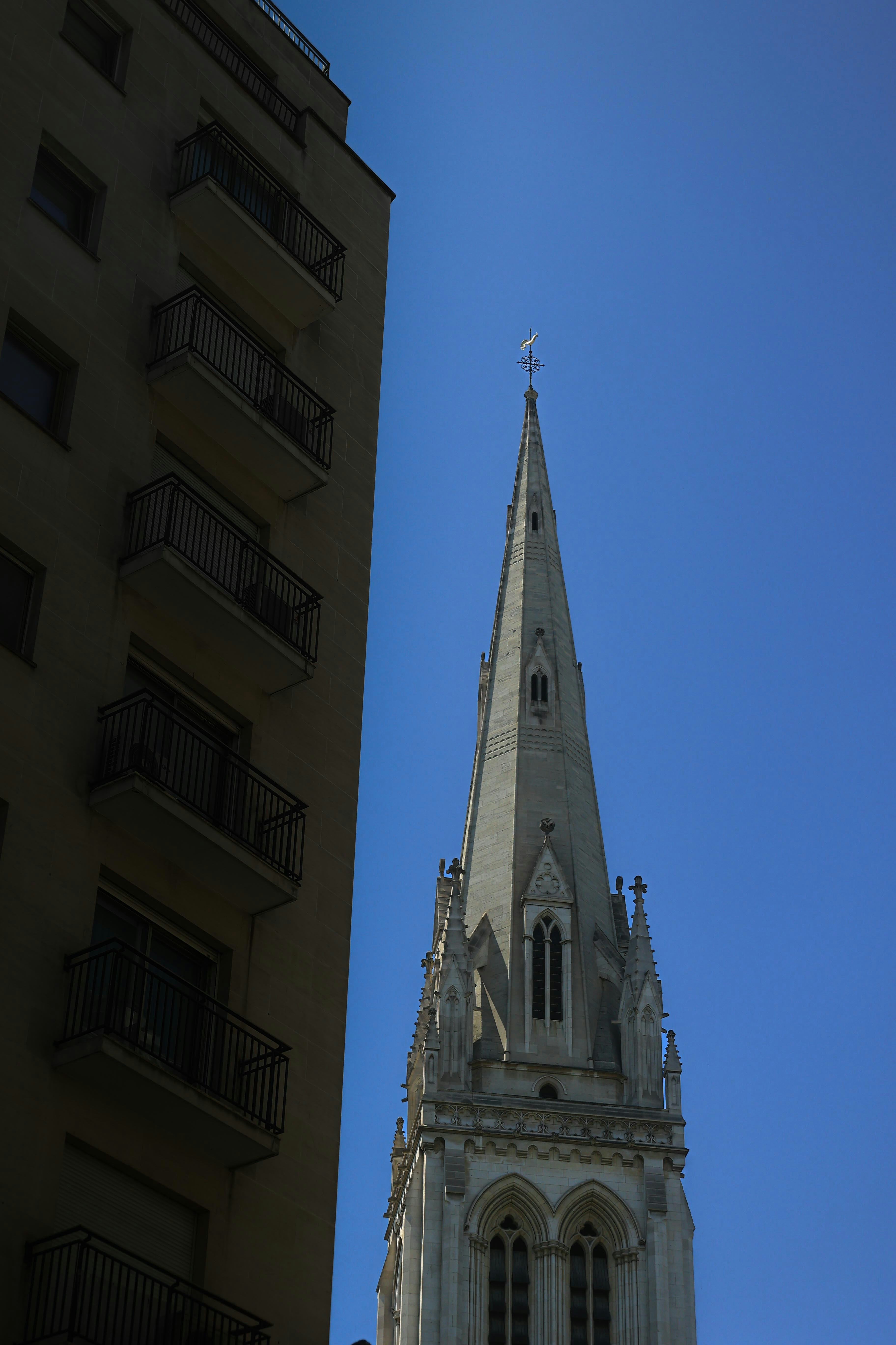 Urban Spire at Noon: Gothic Needle Between Shadow and Sky
