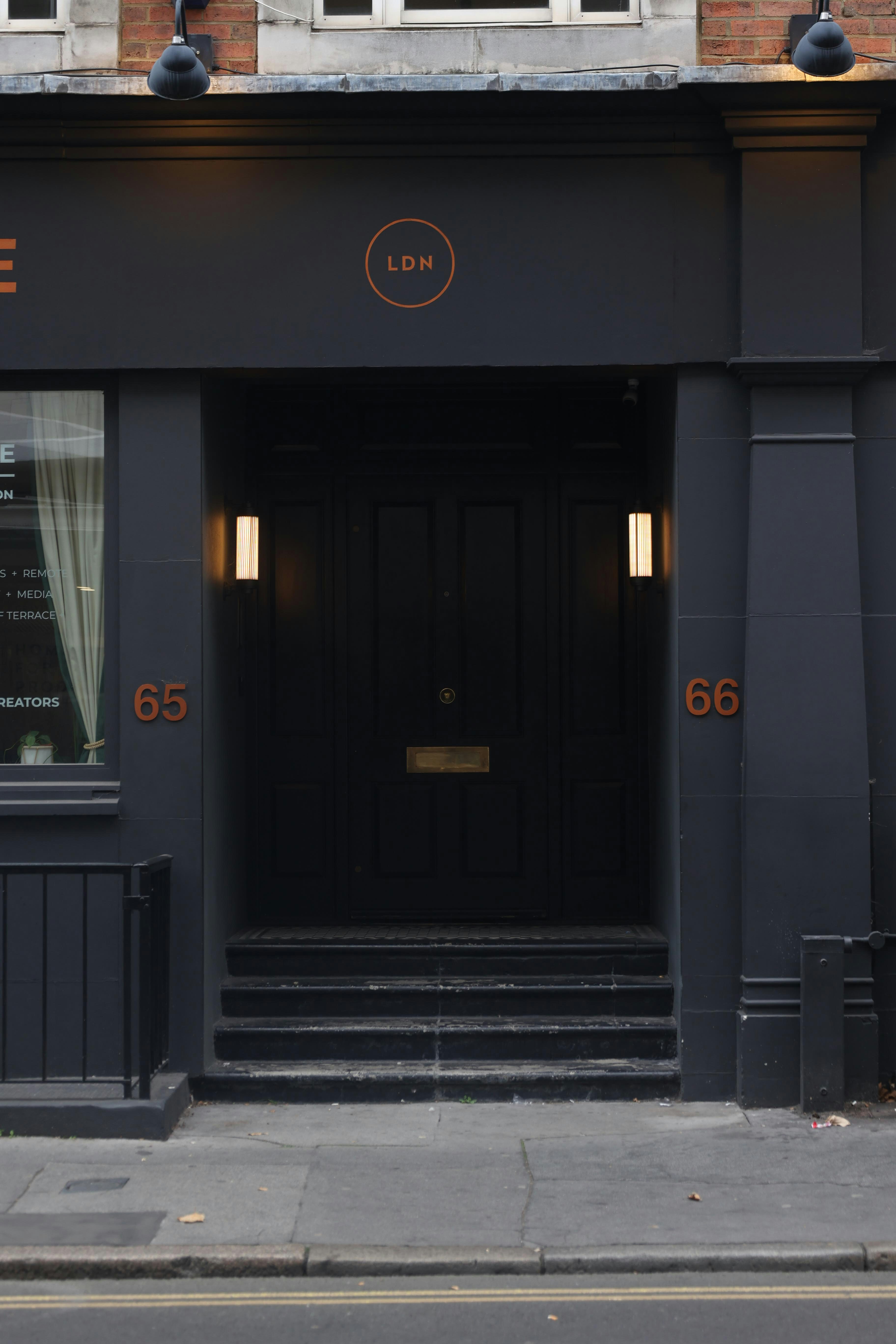 Threshold at No. 65: A Midnight Doorway Flanked by Warm Lamps