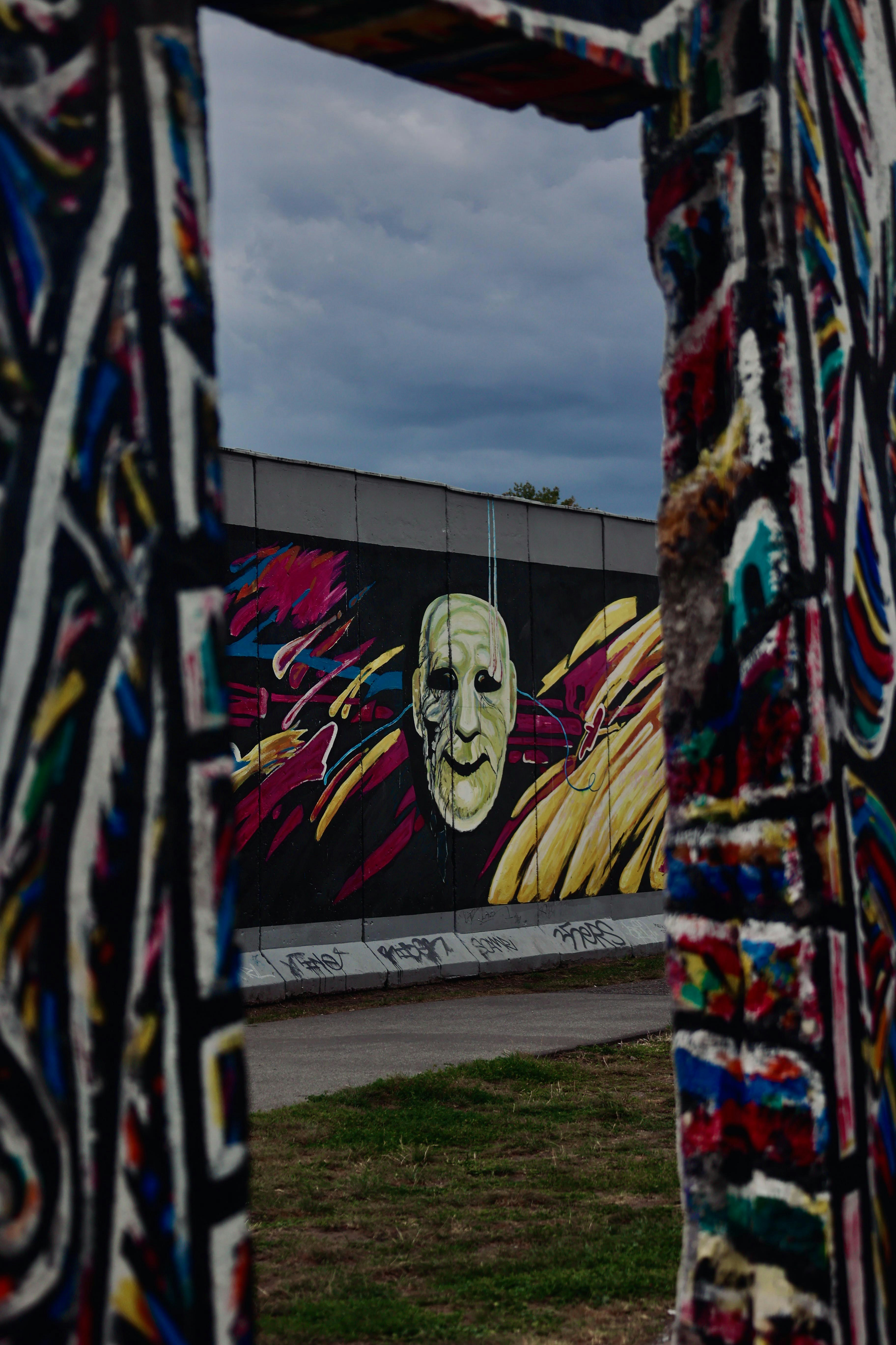 Green Mask in a Graffiti Portal: A Mural Framed by Painted Arches