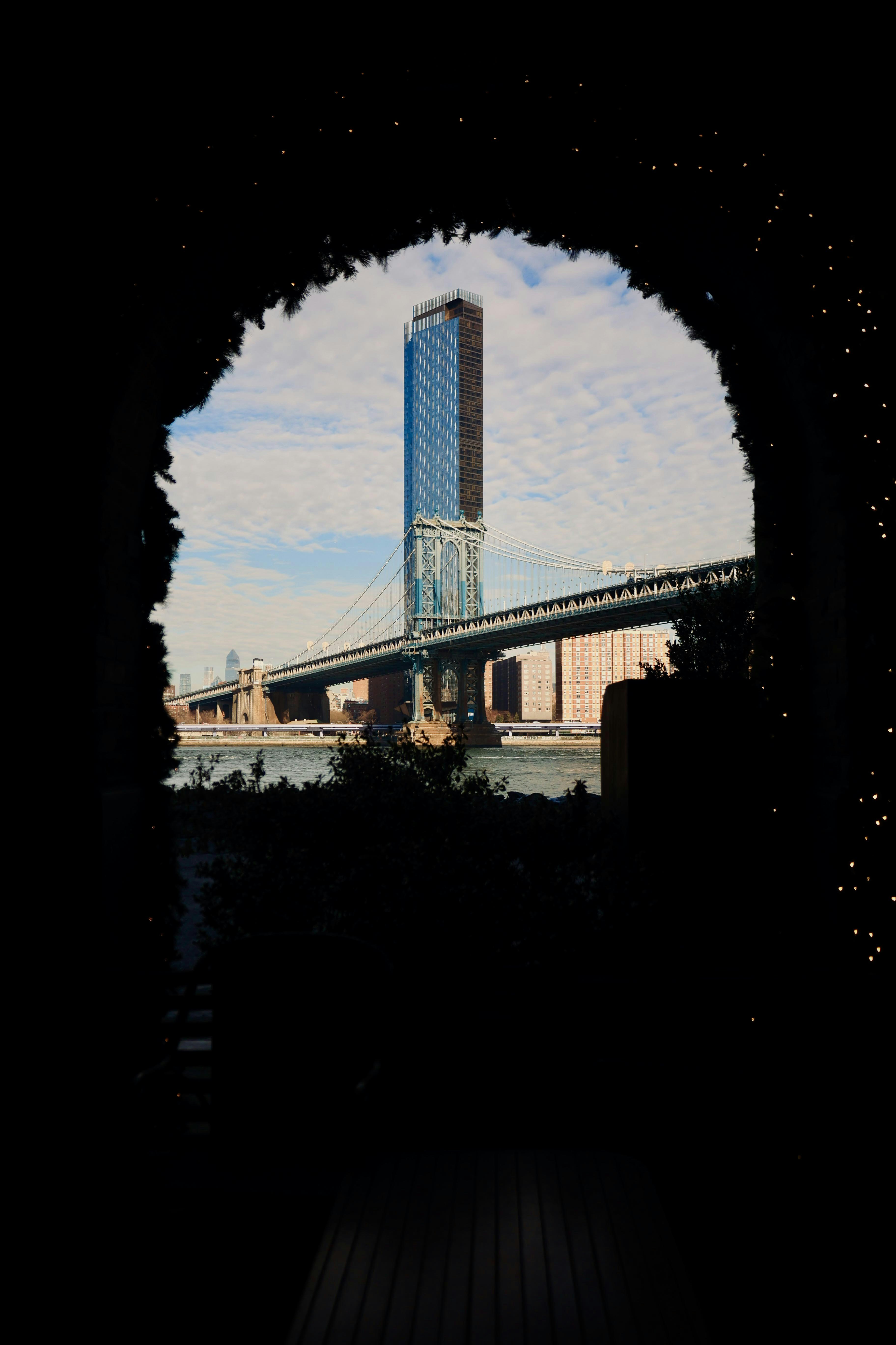 Azure Tower Framed by a Lantern-Outlined Arch Over the River Bridge
