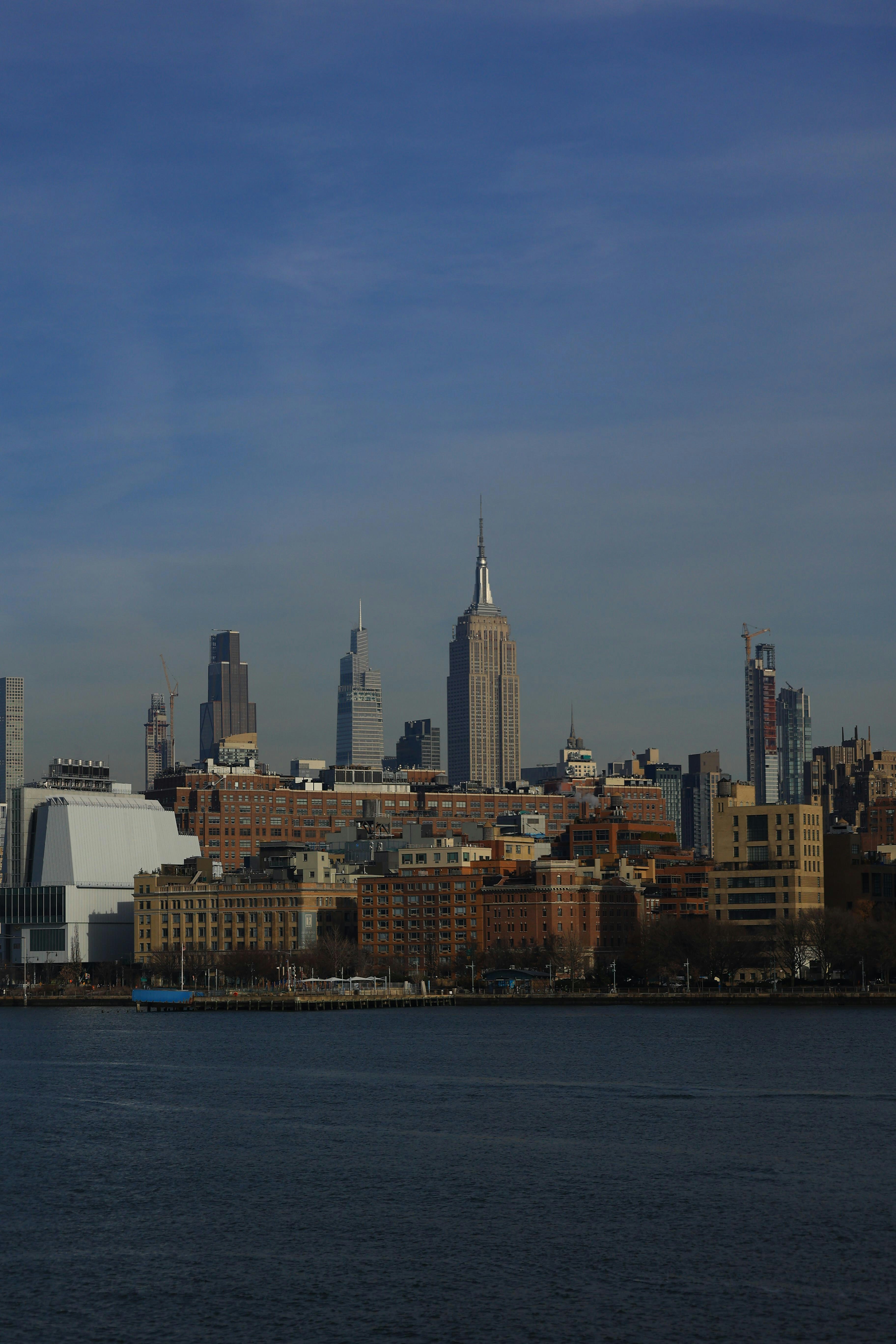 Empire in Blue: Manhattan’s Crowned Skyline over the River
