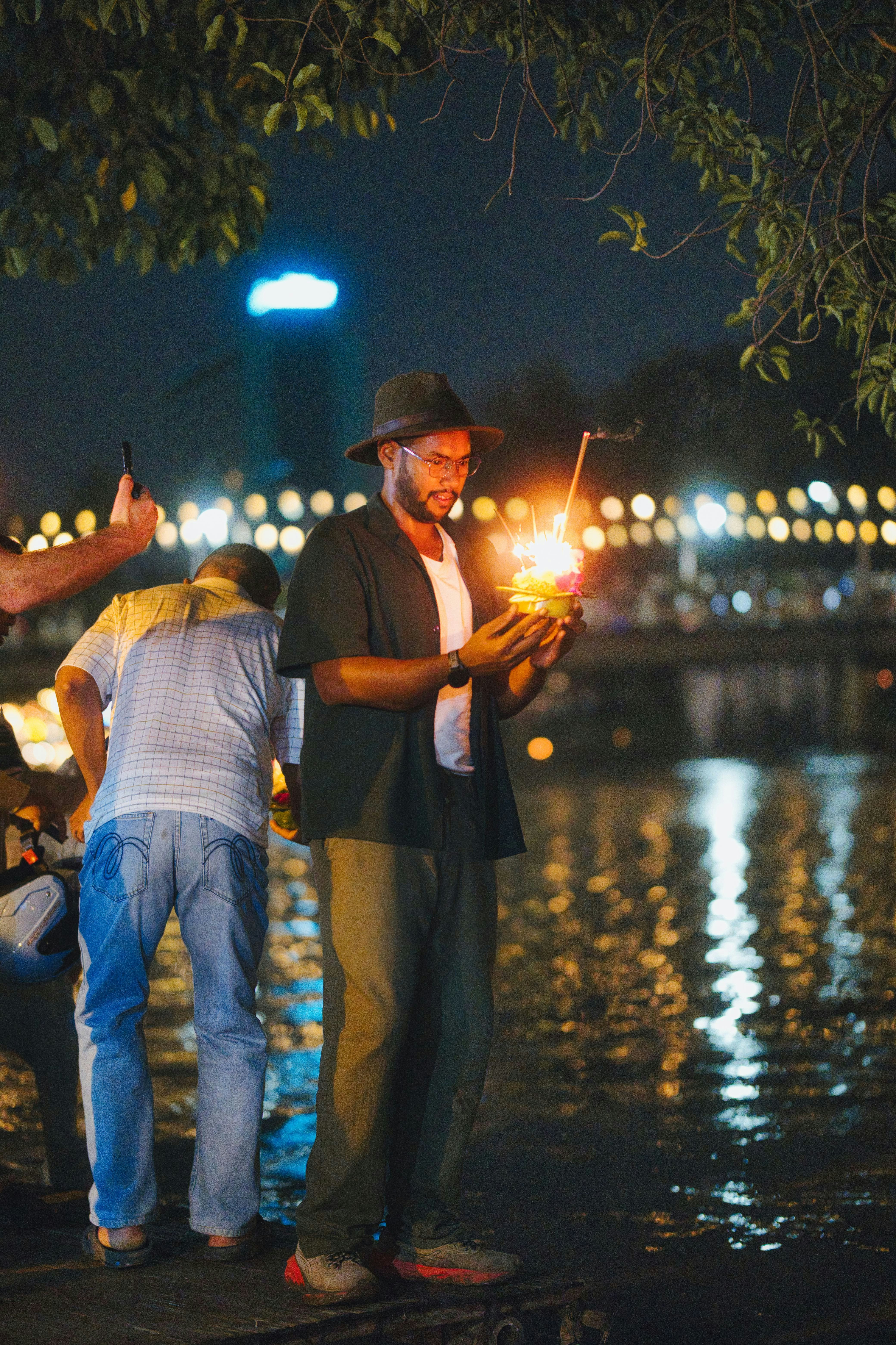 Torchlight by the River: A Solo Moment Amid City Reflections