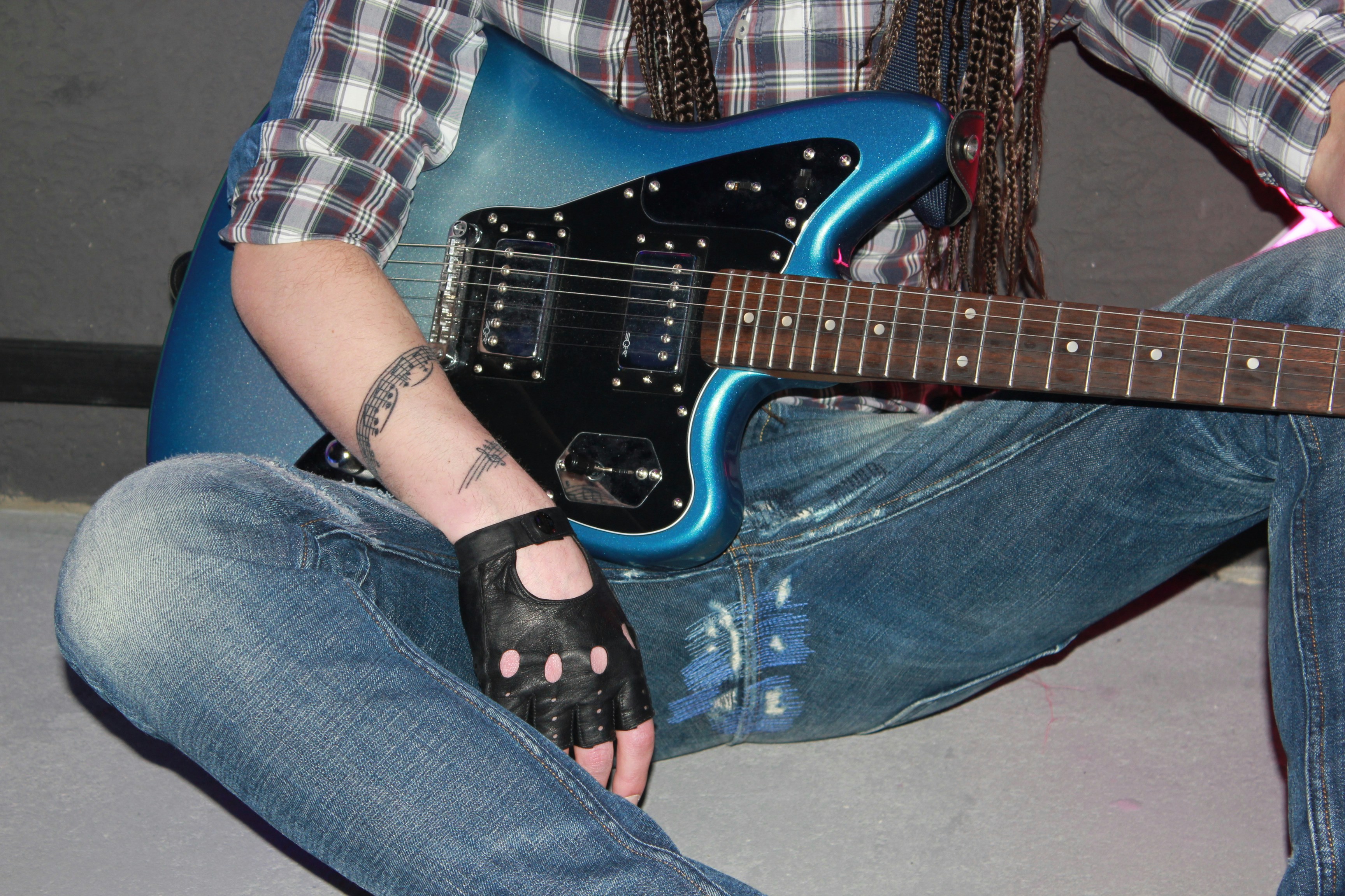 Blue Electric Quiet: A Denim-Clad Guitarist Pauses on Concrete