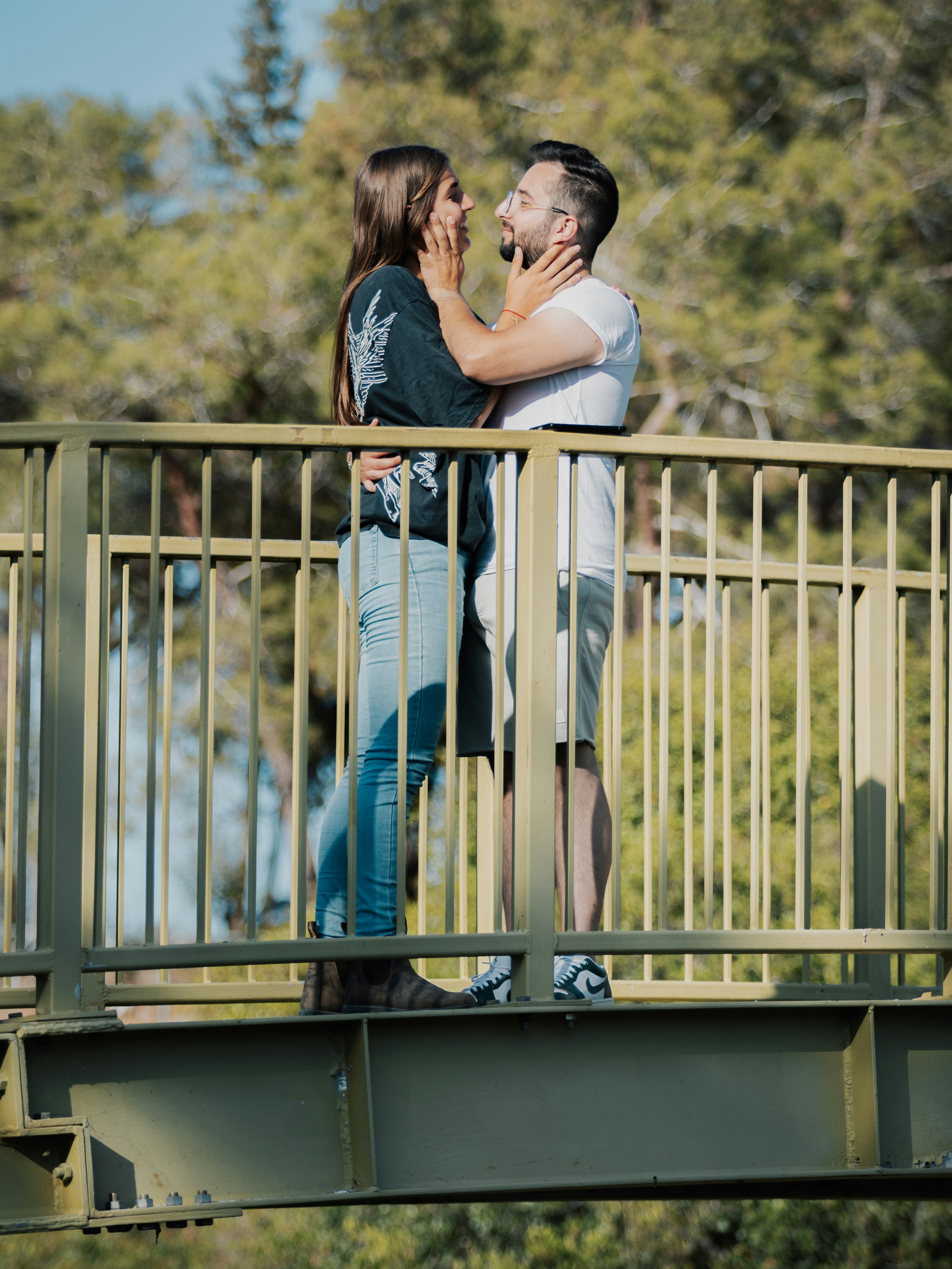 A couple embracing on a bridge outdoors. photo – Free Love Image on ...