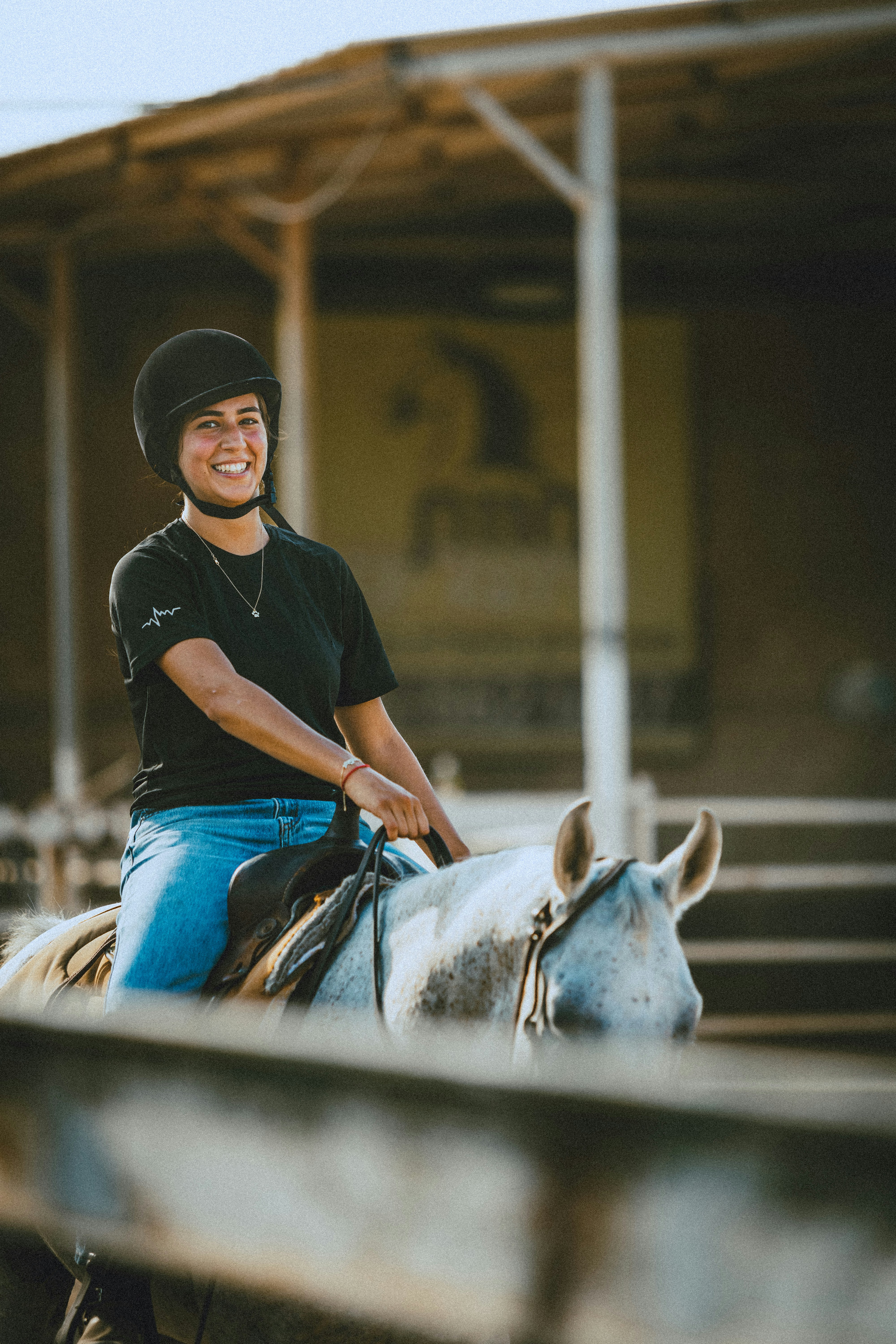 Sunlit Arena Moment: Confident Rider on a White Horse