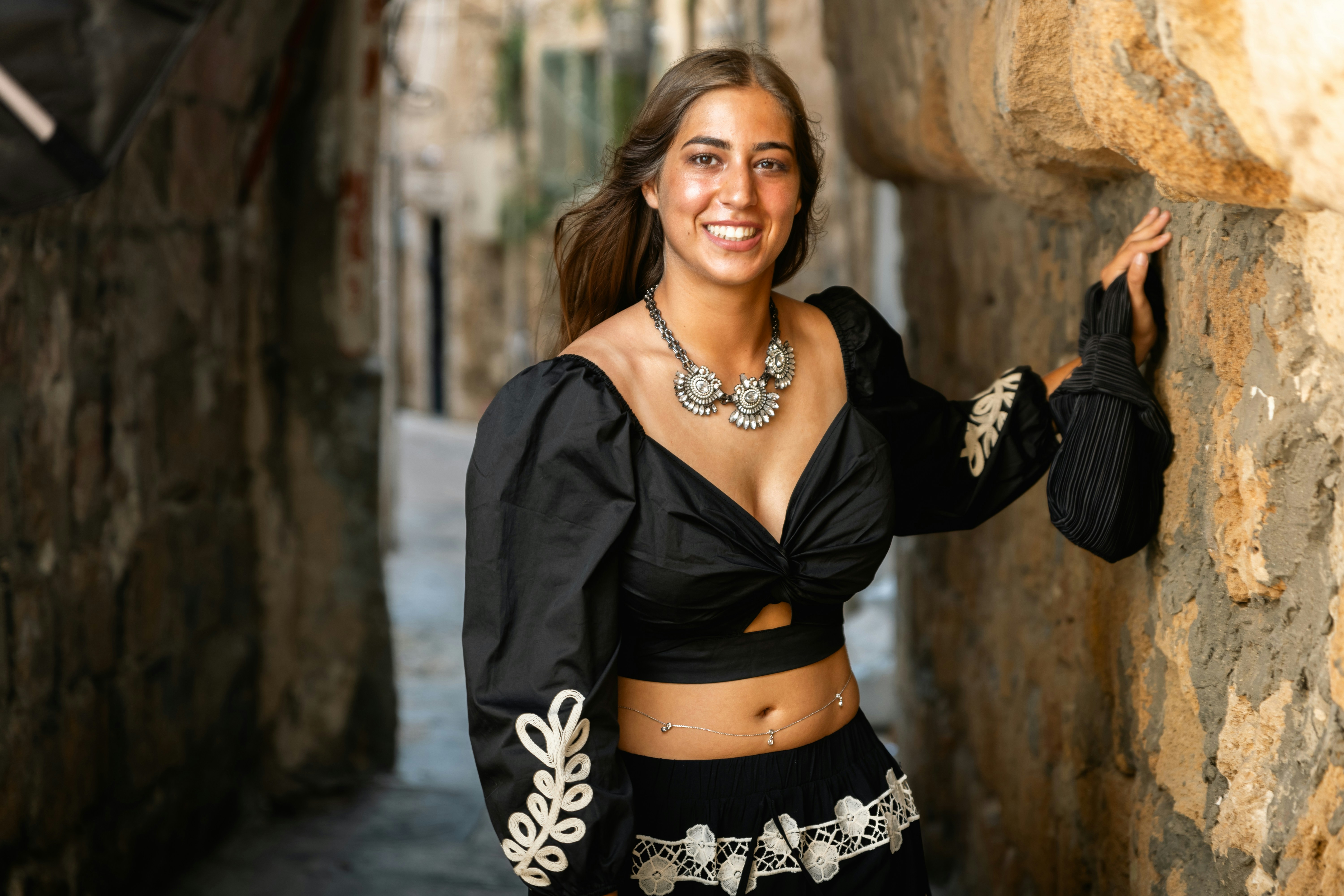 Sunlit Alley Portrait: Black Velvet, Silver Embroidery, and a Confident Smile
