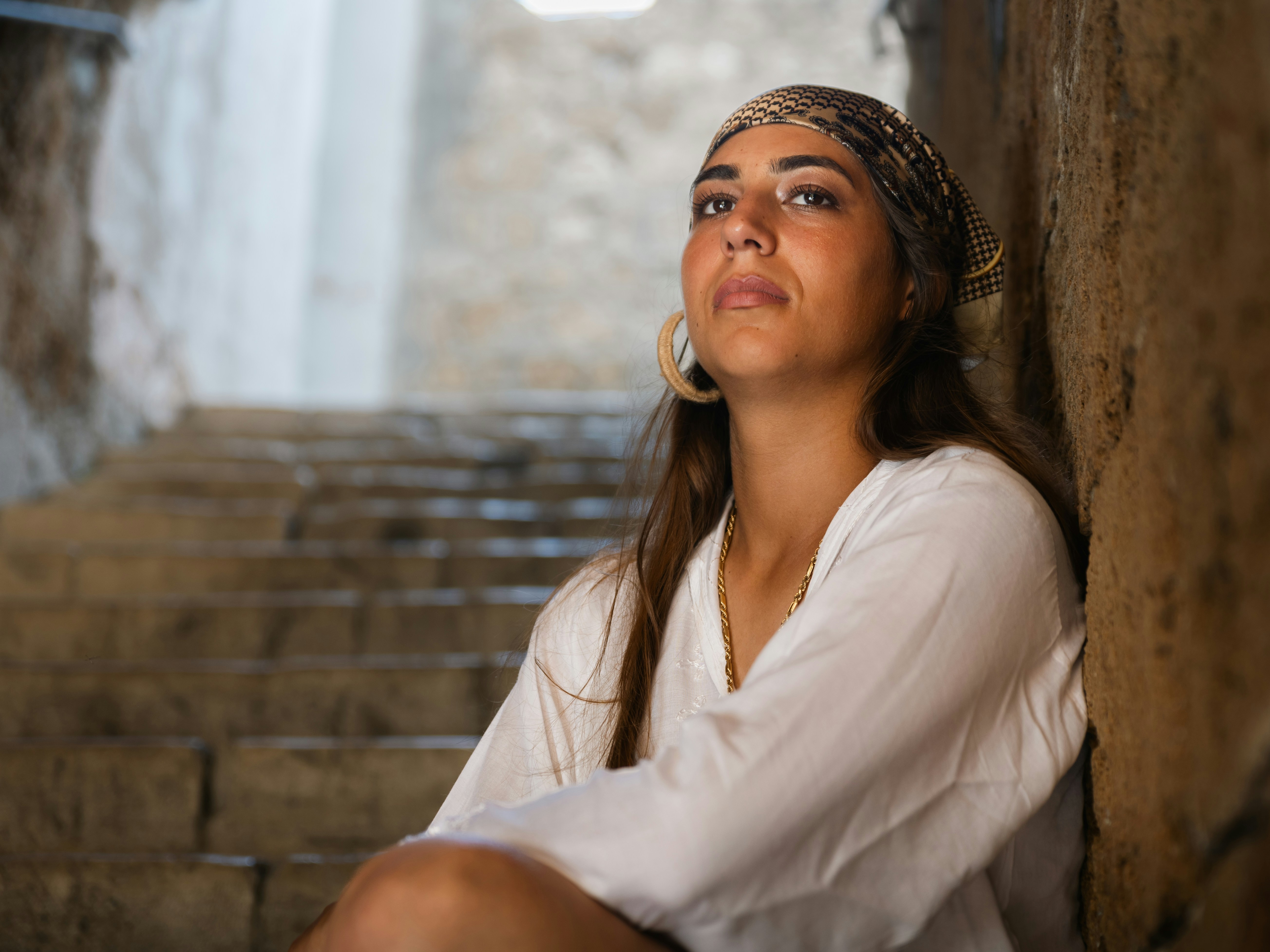Portrait Beneath a Curtain of Light on Weathered Stone Steps