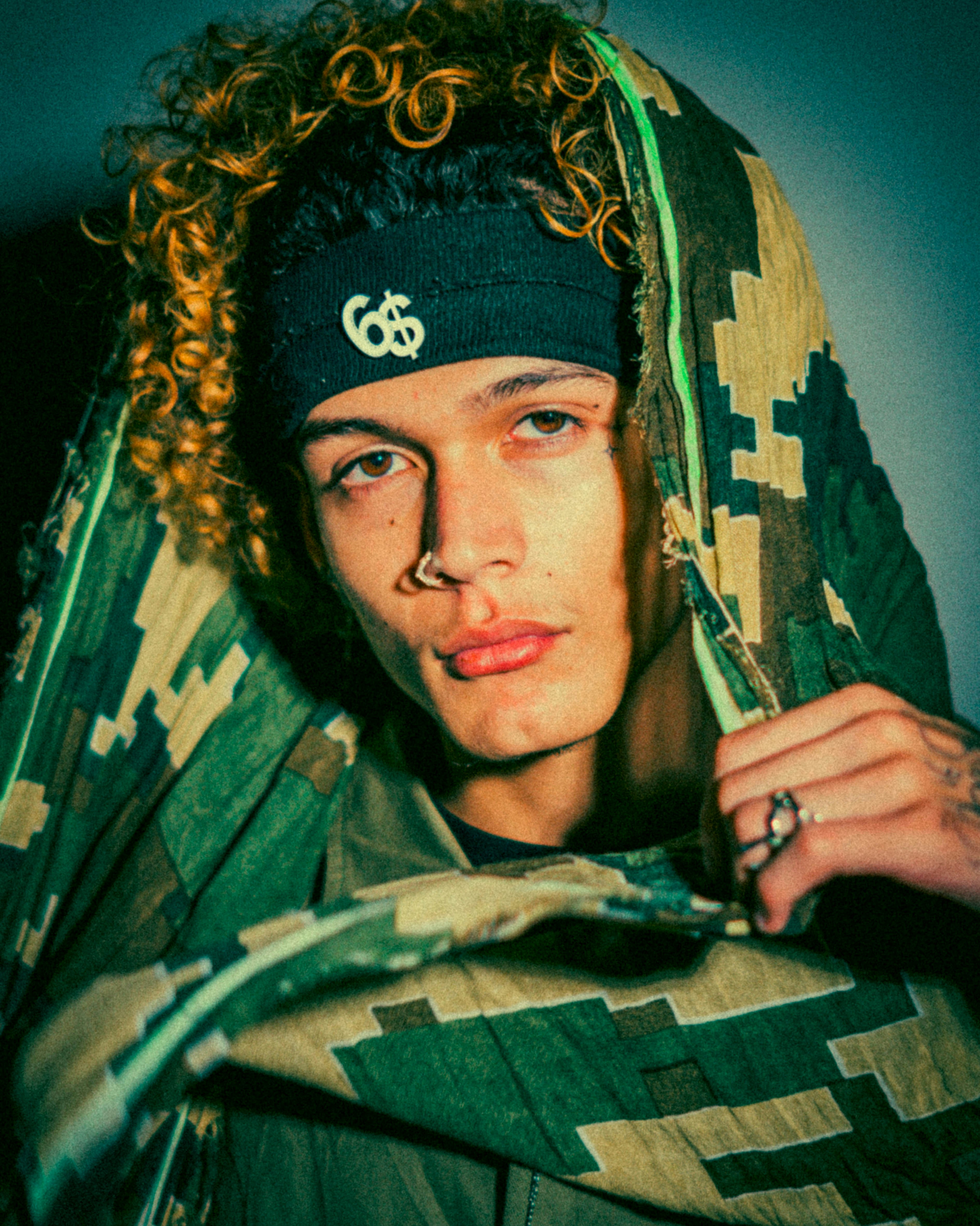 Gaze Through Camouflage: A Neon-Toned Portrait of a Young Man