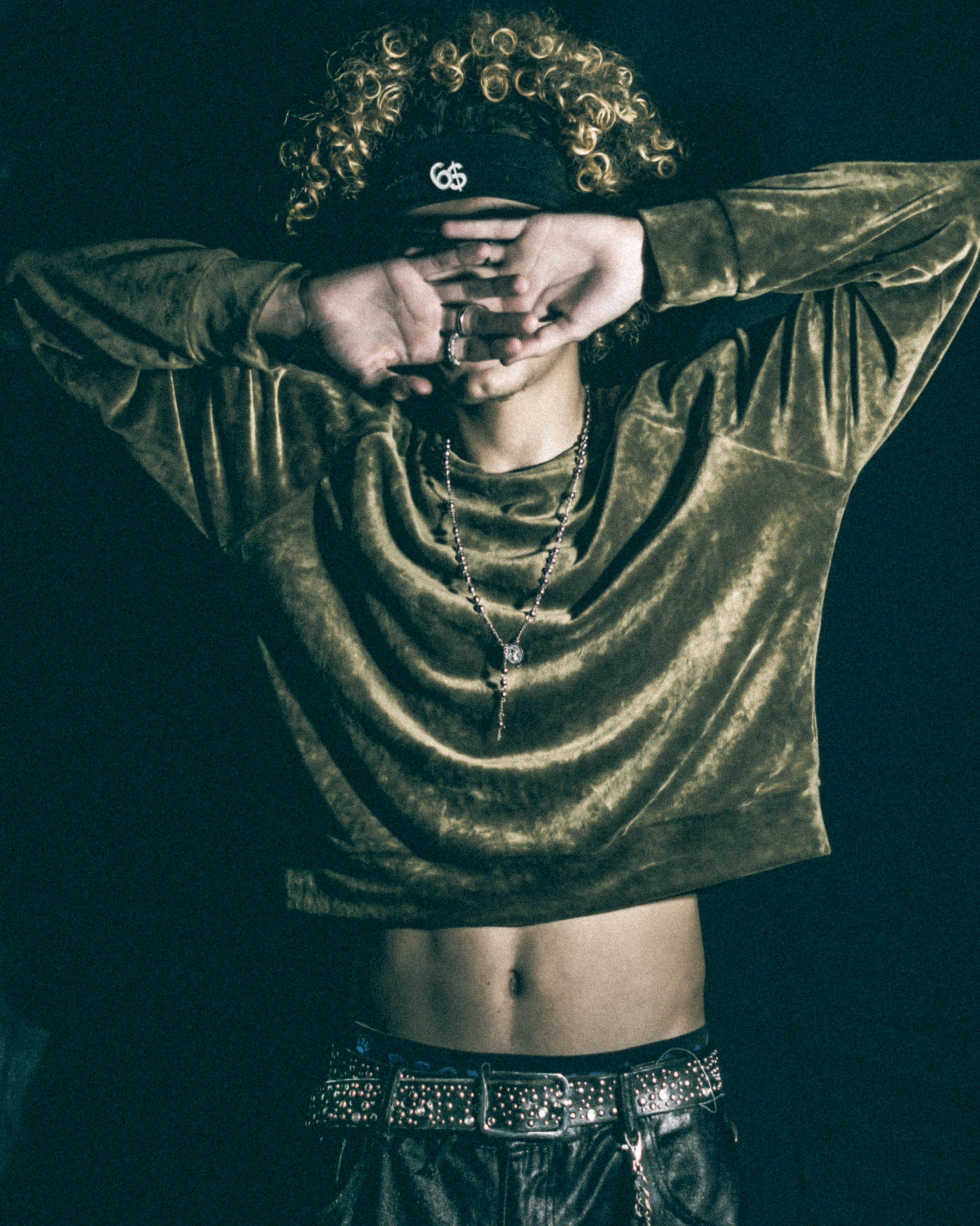 Velvet Green and Studded Silence: A Portrait with Hands Concealing the Face