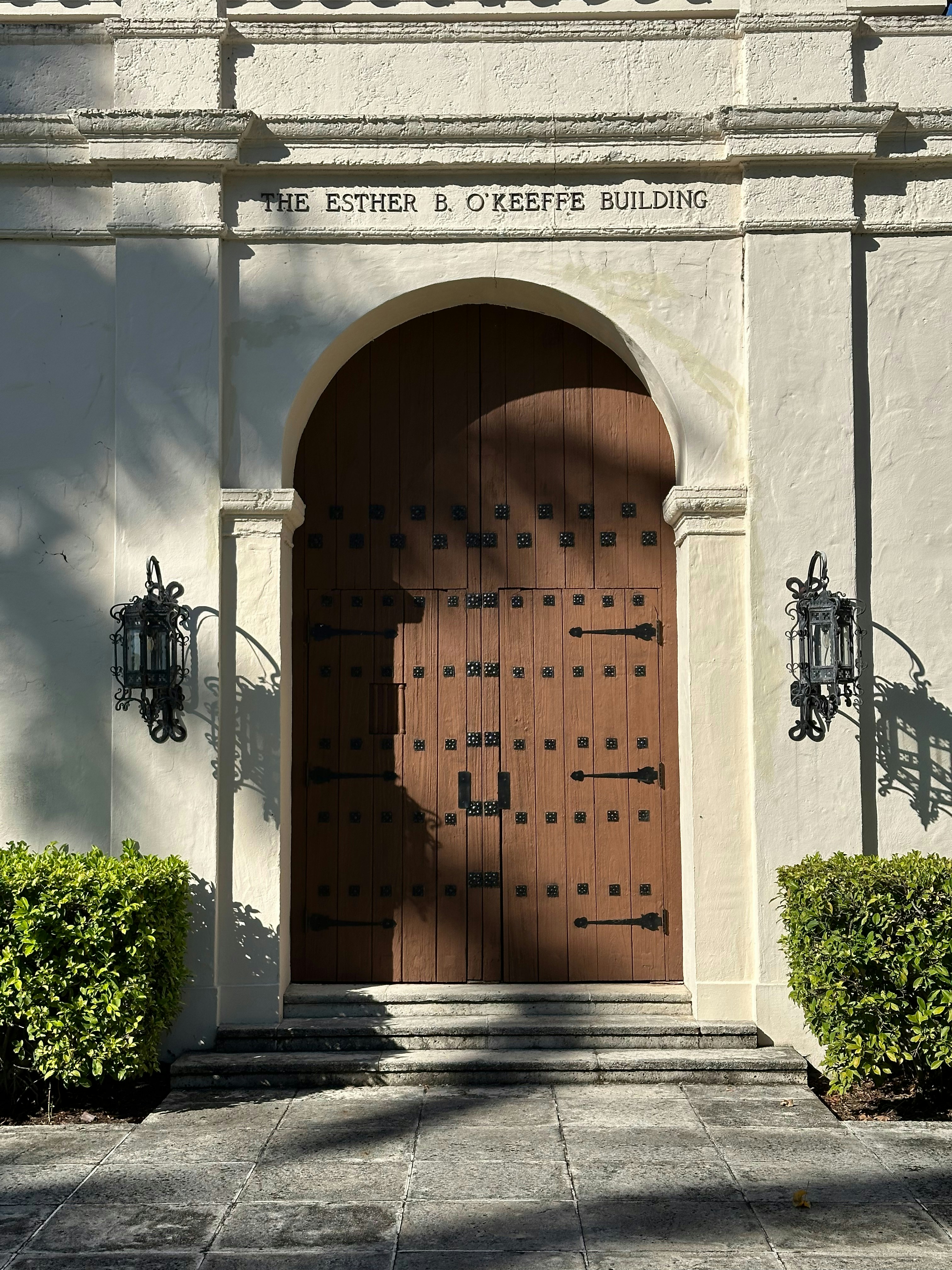 Sunlit Portal: The Iron-Studded Wooden Door of The Esther B. O'Keeffe Building