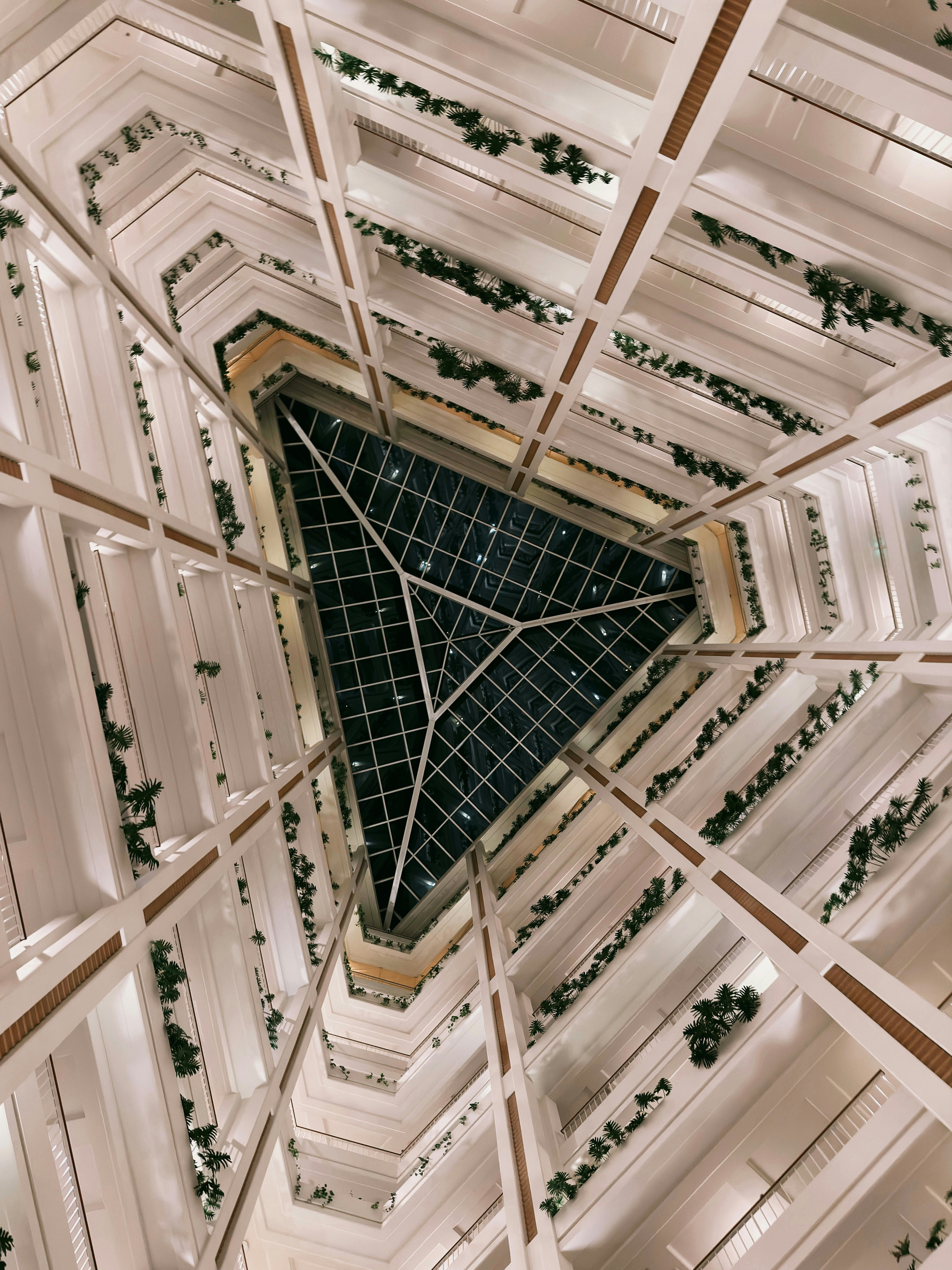 Converging Rails: A Triangular Skylight Framing a Verdant Atrium