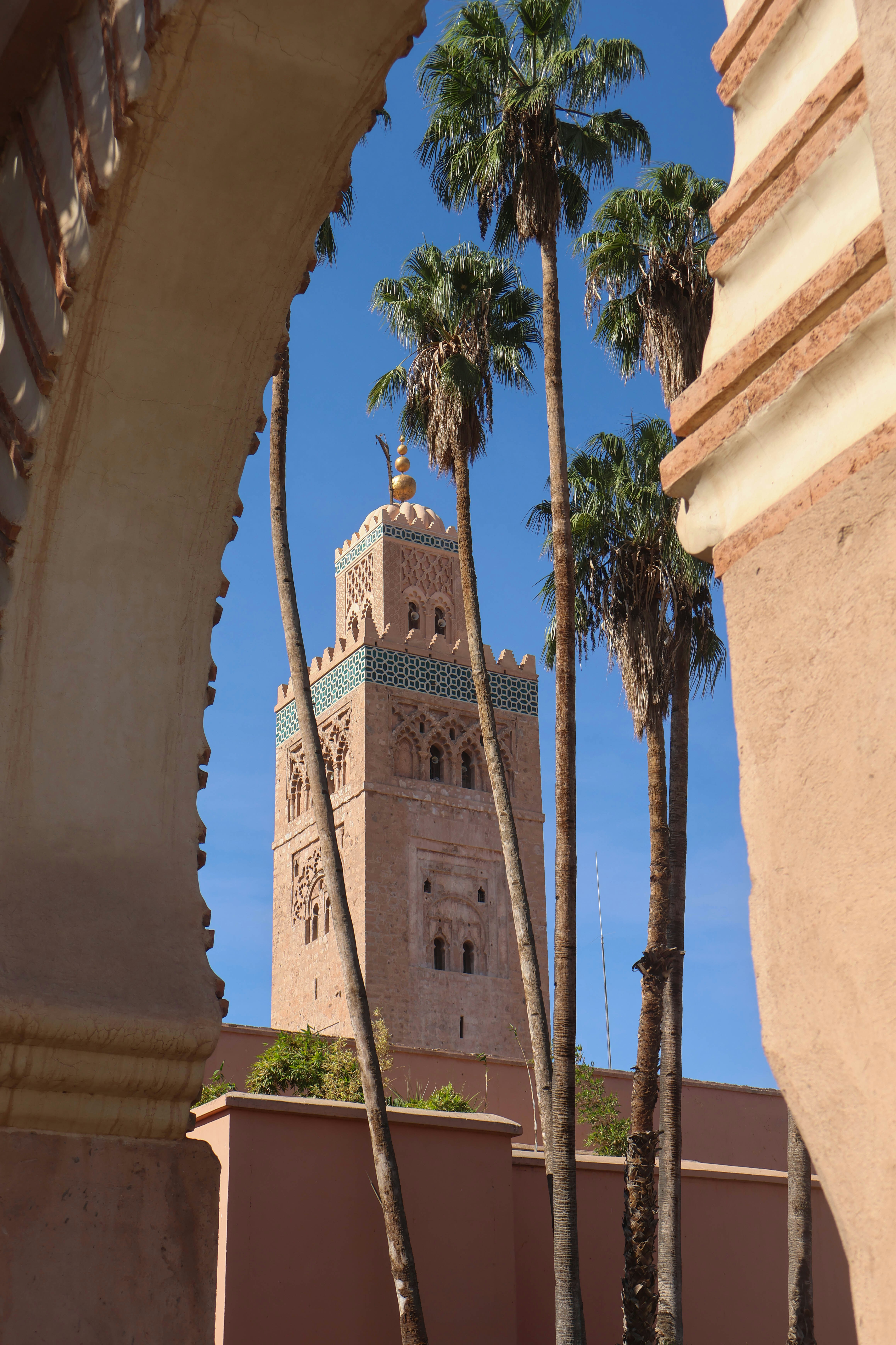 Minaret in Palm-Lined Light: Archways Framing a Desert Tower