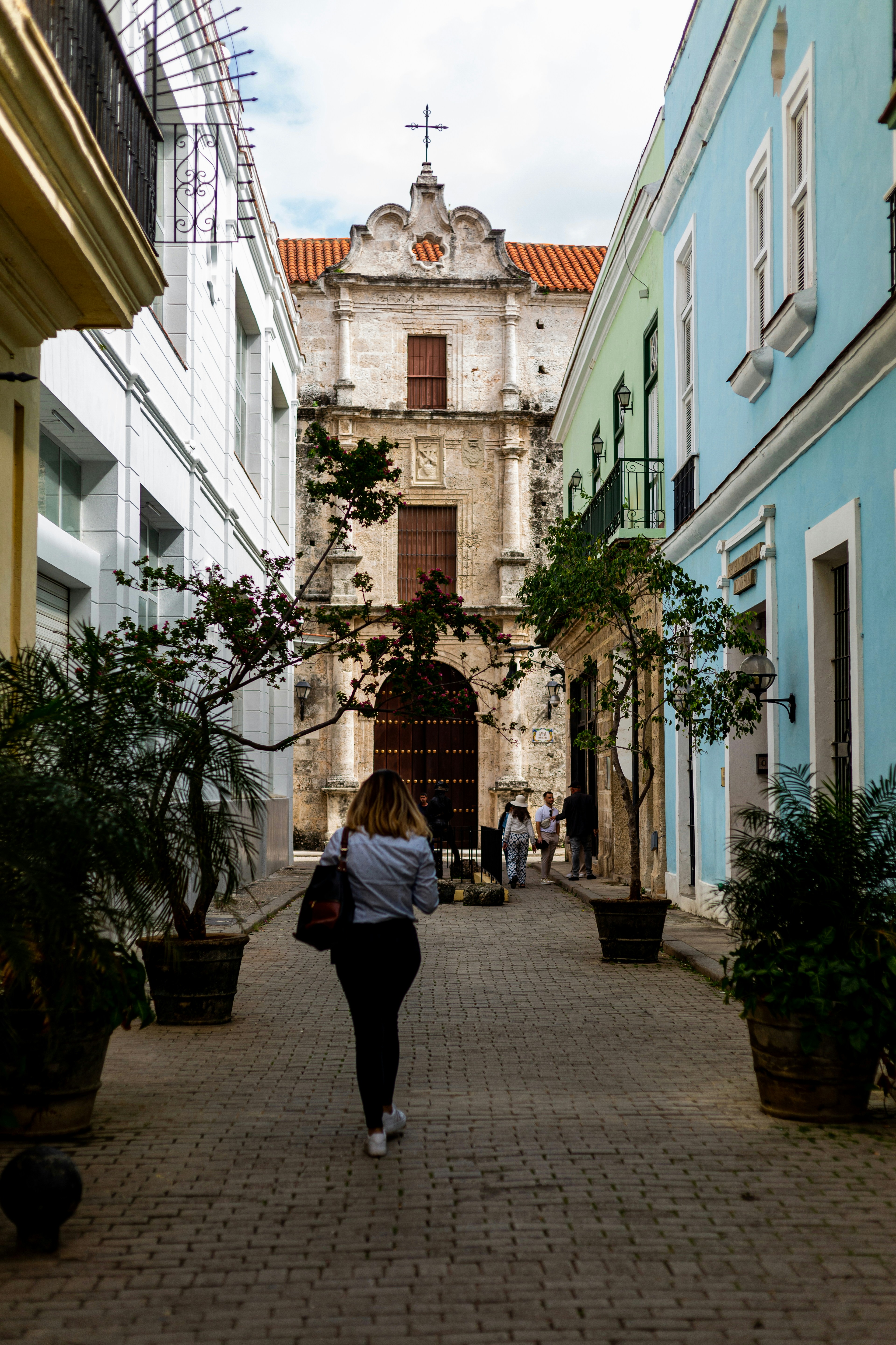 Portal at the Calle: Weathered Church Framed by Pastel Townhouses