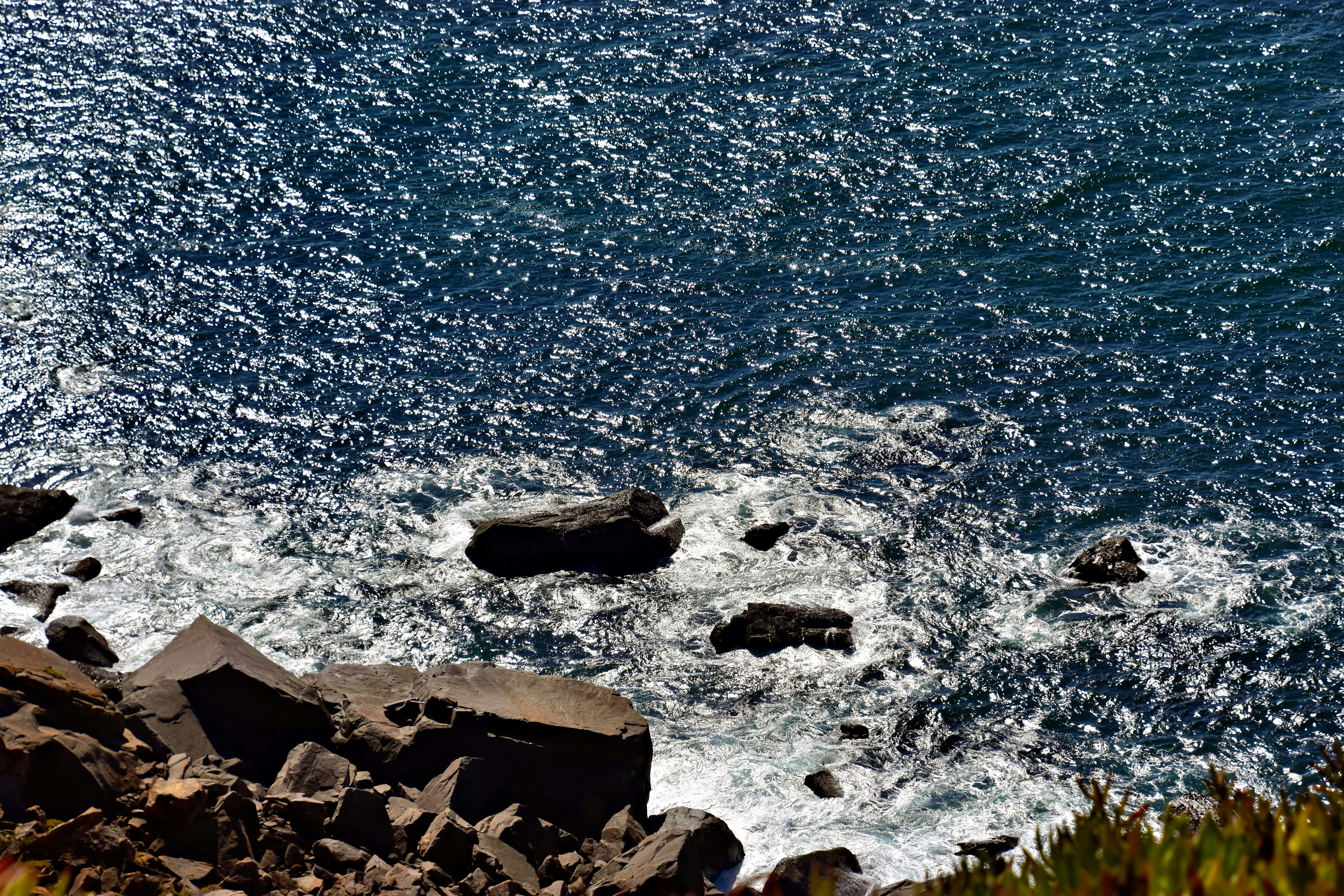 Sunlit Basalt at the Edge: Coastal Rocks Meet Cobalt Sea