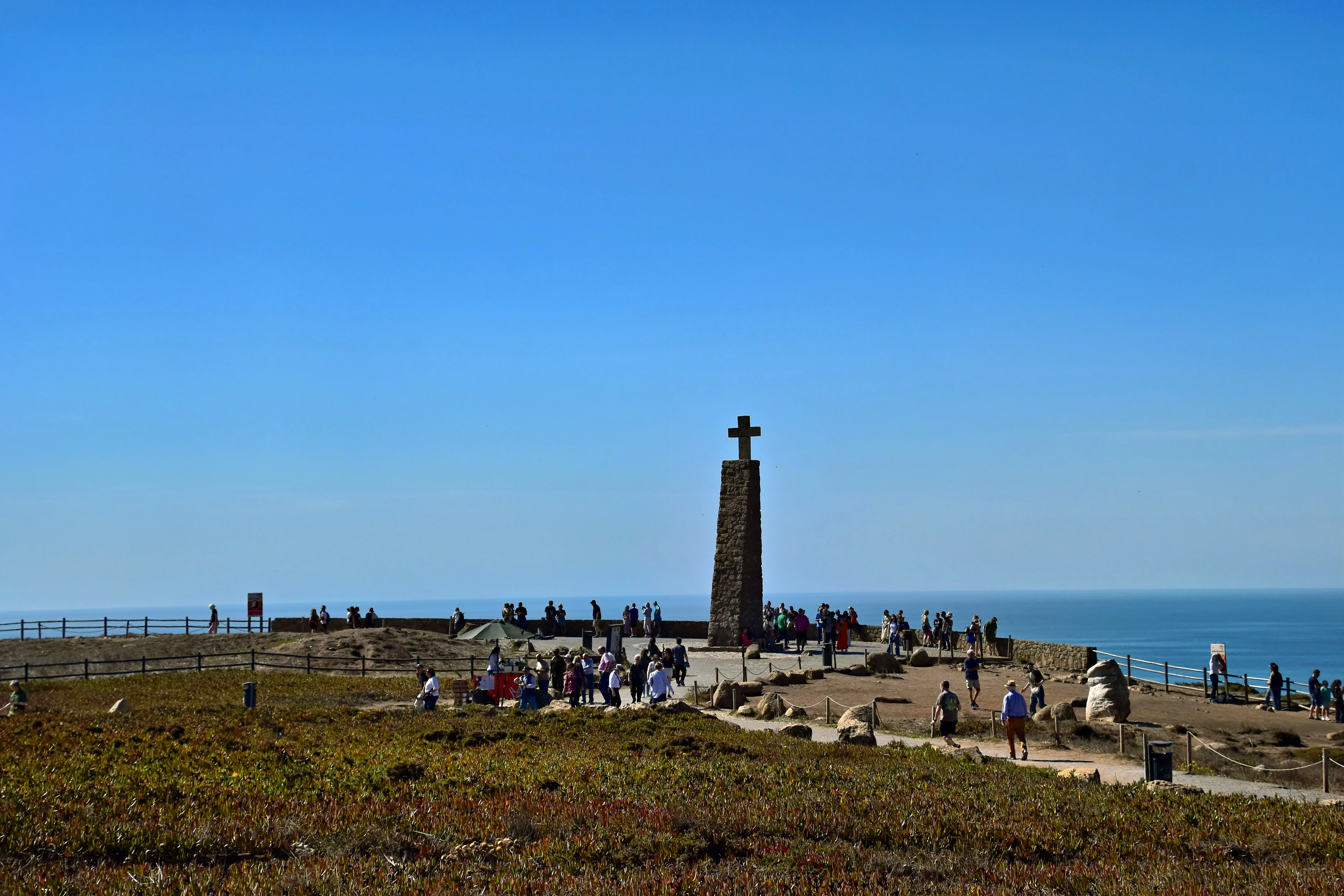 Cross on the Promontory: Crowds Gather Along the Sea-Washed Plaza