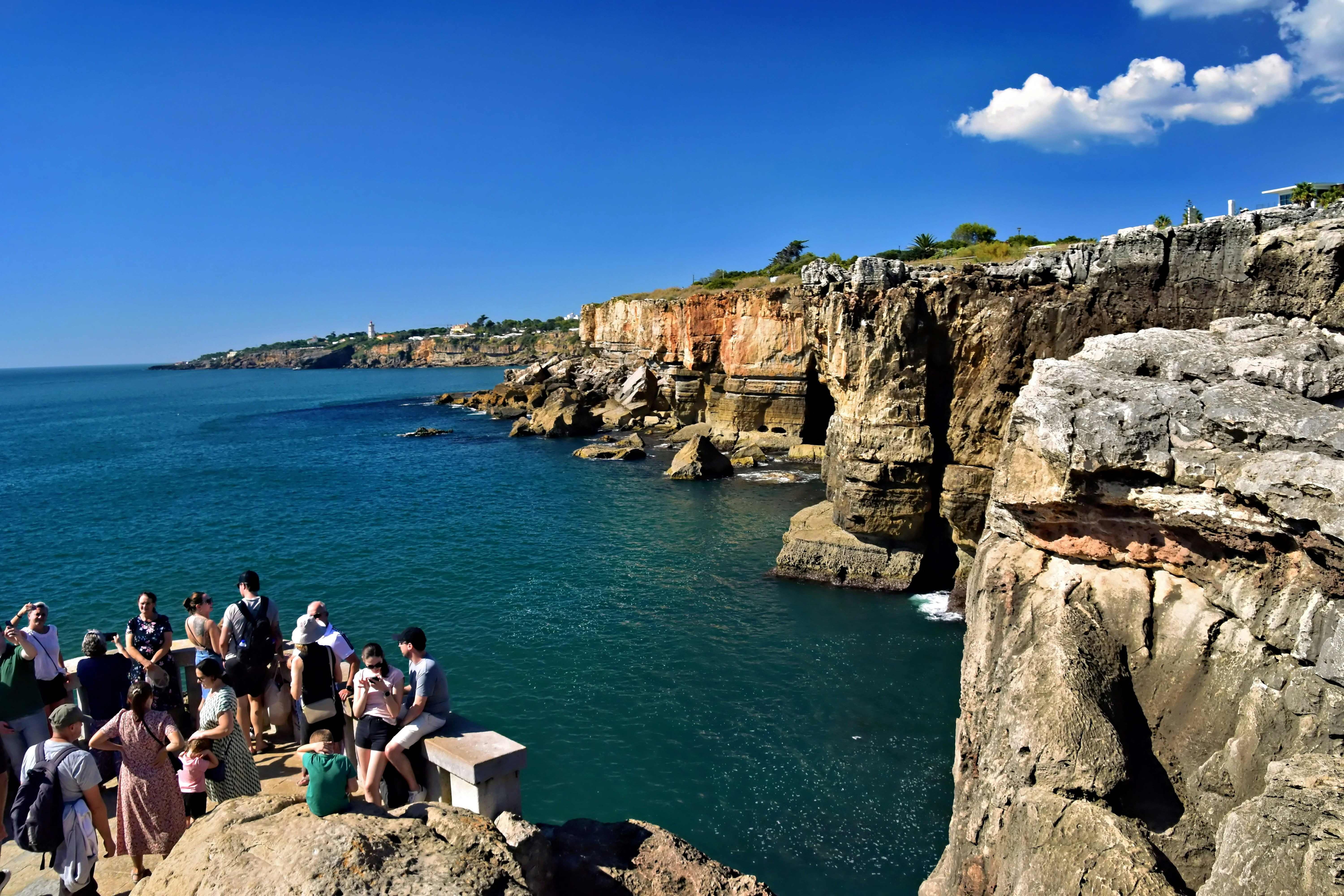People admire ocean views from rocky cliffs