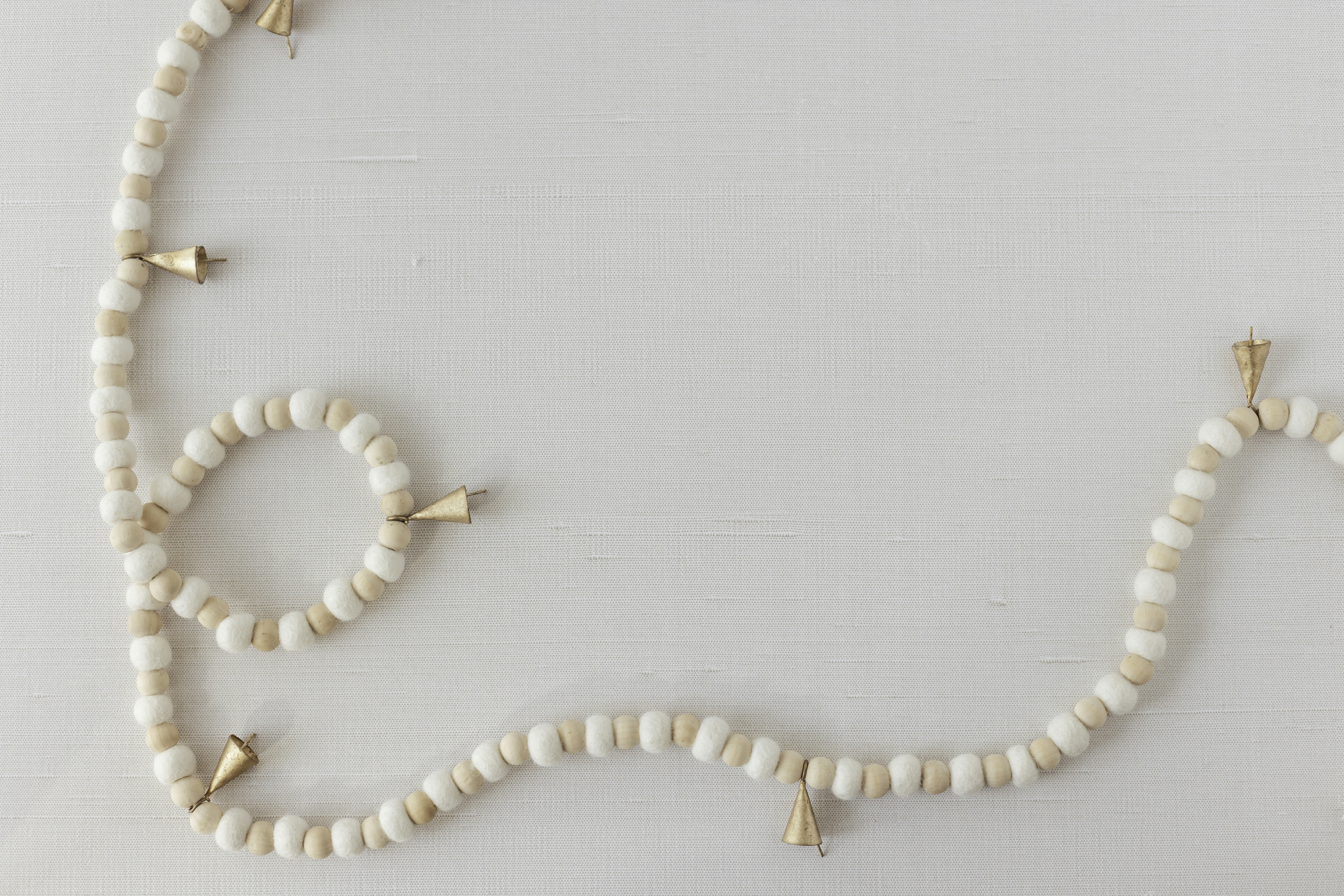 Curved Bead Script on a Quiet White Canvas