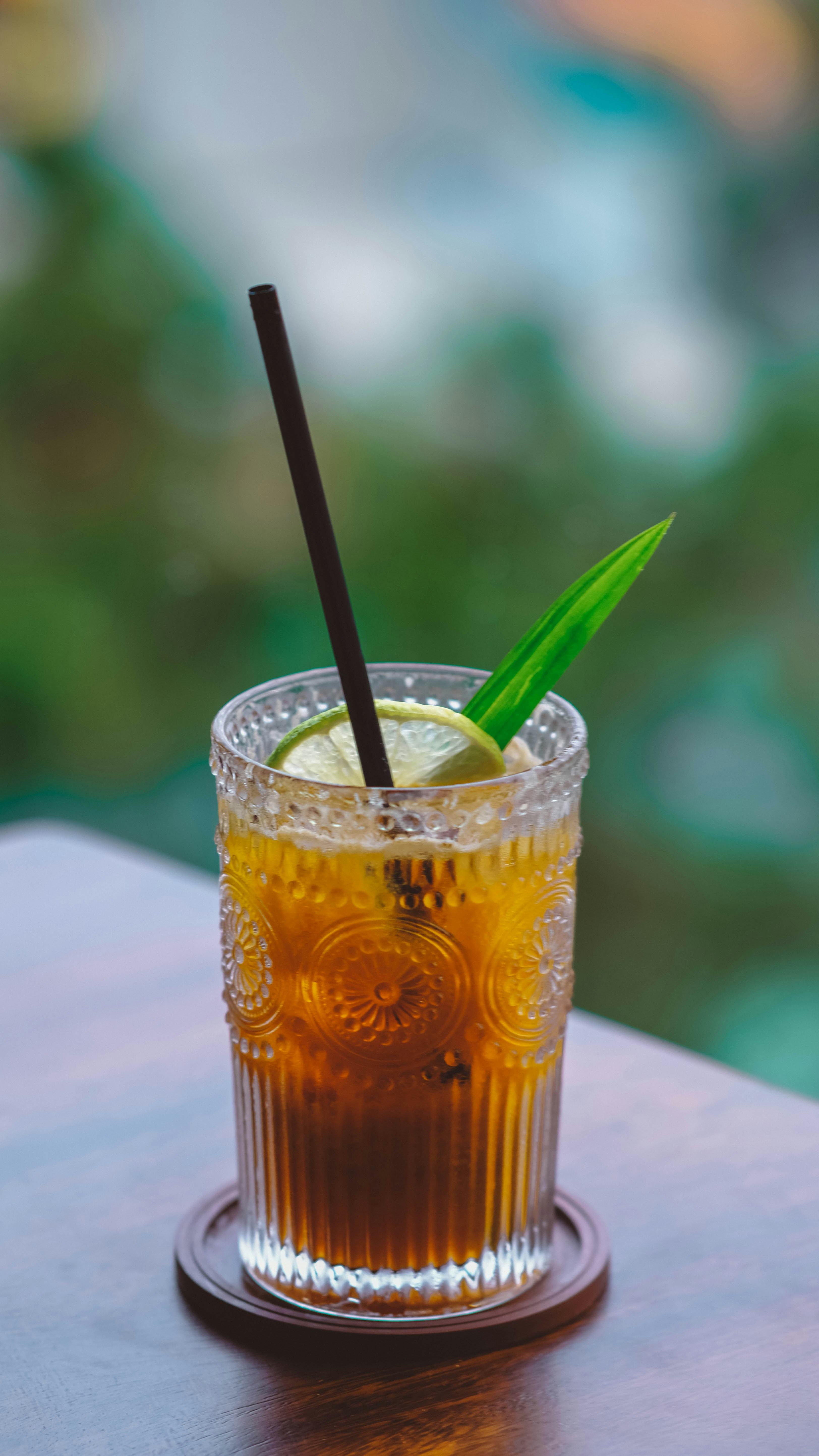 Amber Iced Cocktail in an Ornate Glass on a Quiet Wooden Table
