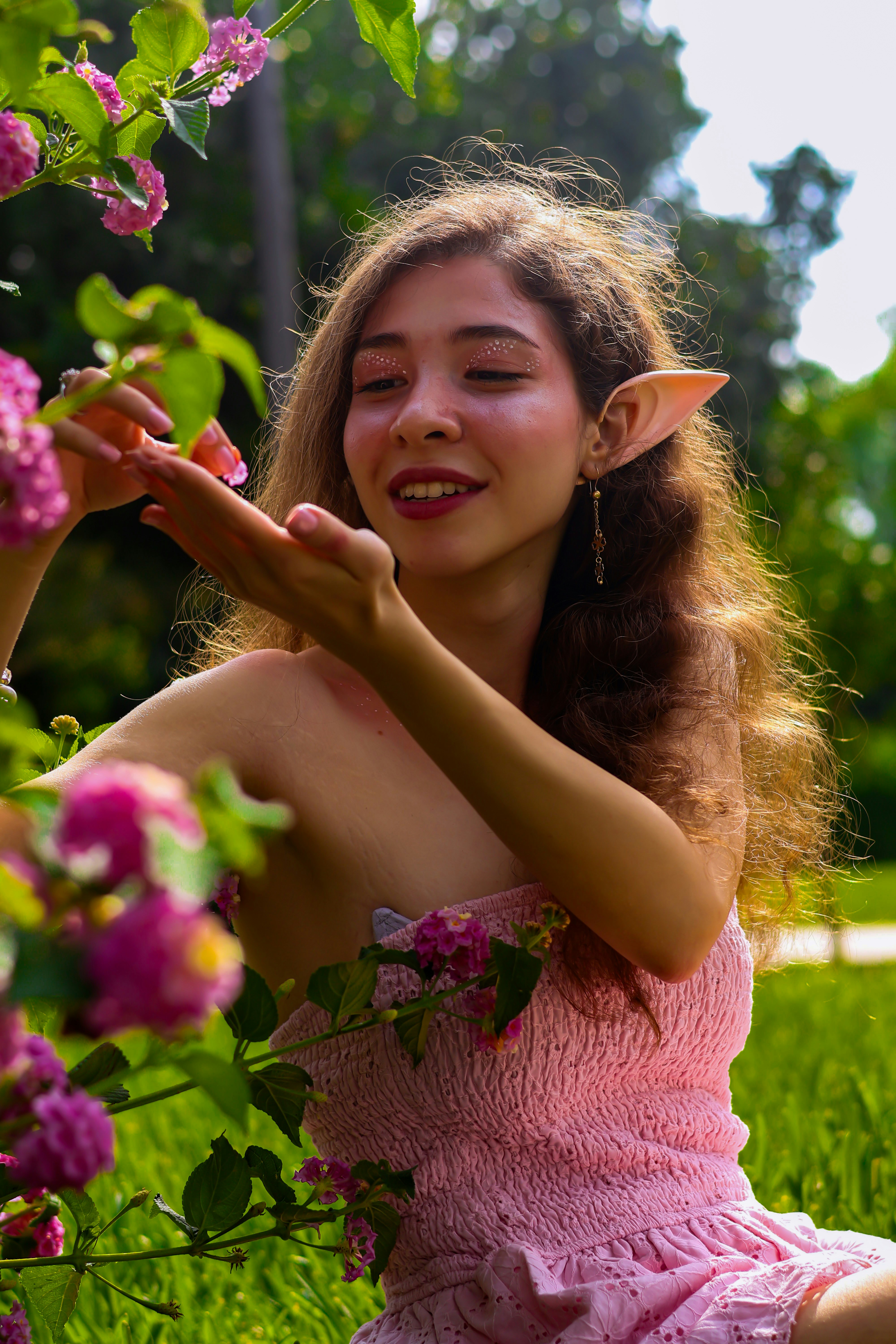 Elf-Eared Muse Among Pink Blooms: A Sunlit Garden Portrait