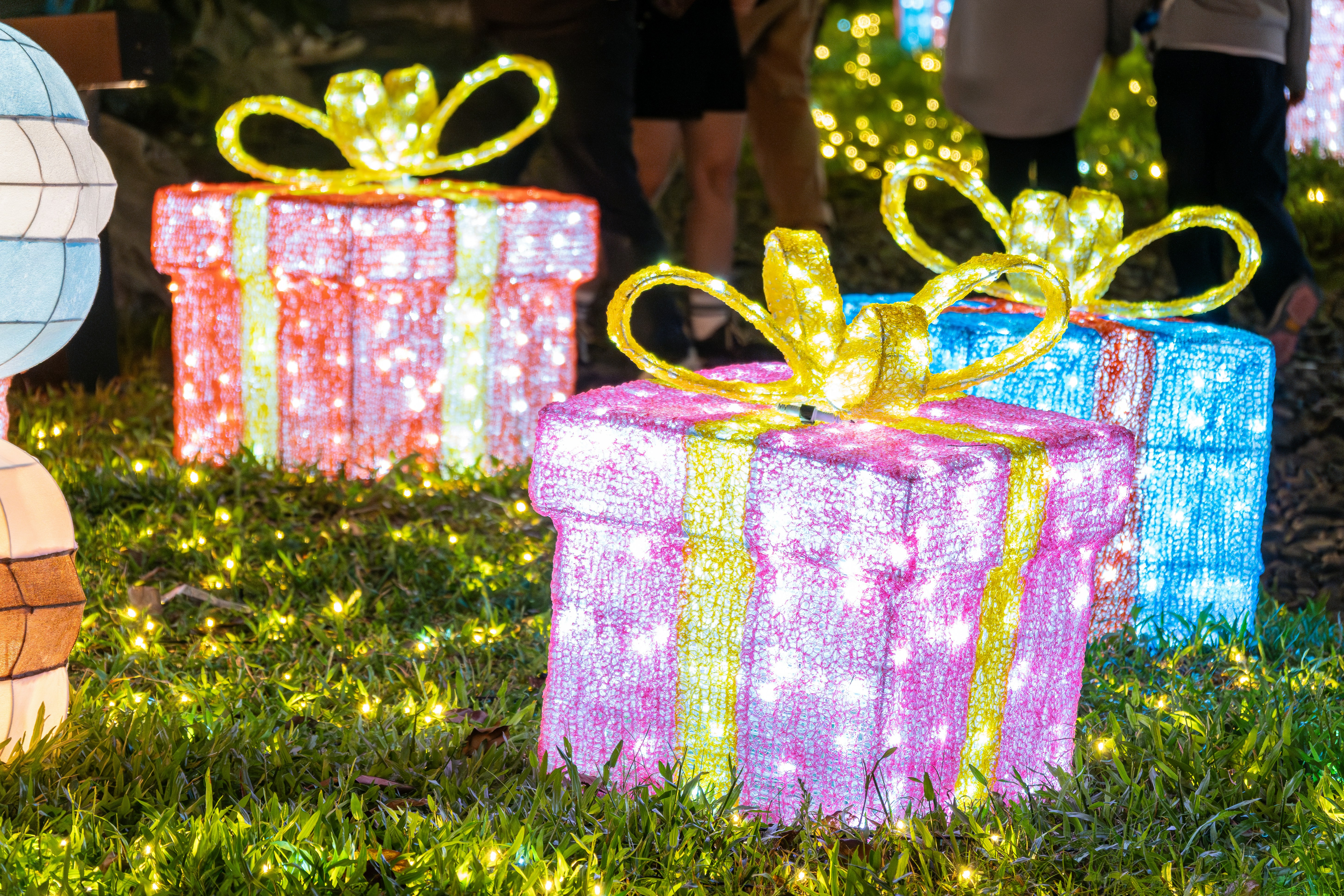 Neon Gift Boxes on Grass: A Night-Lit Holiday Tableau