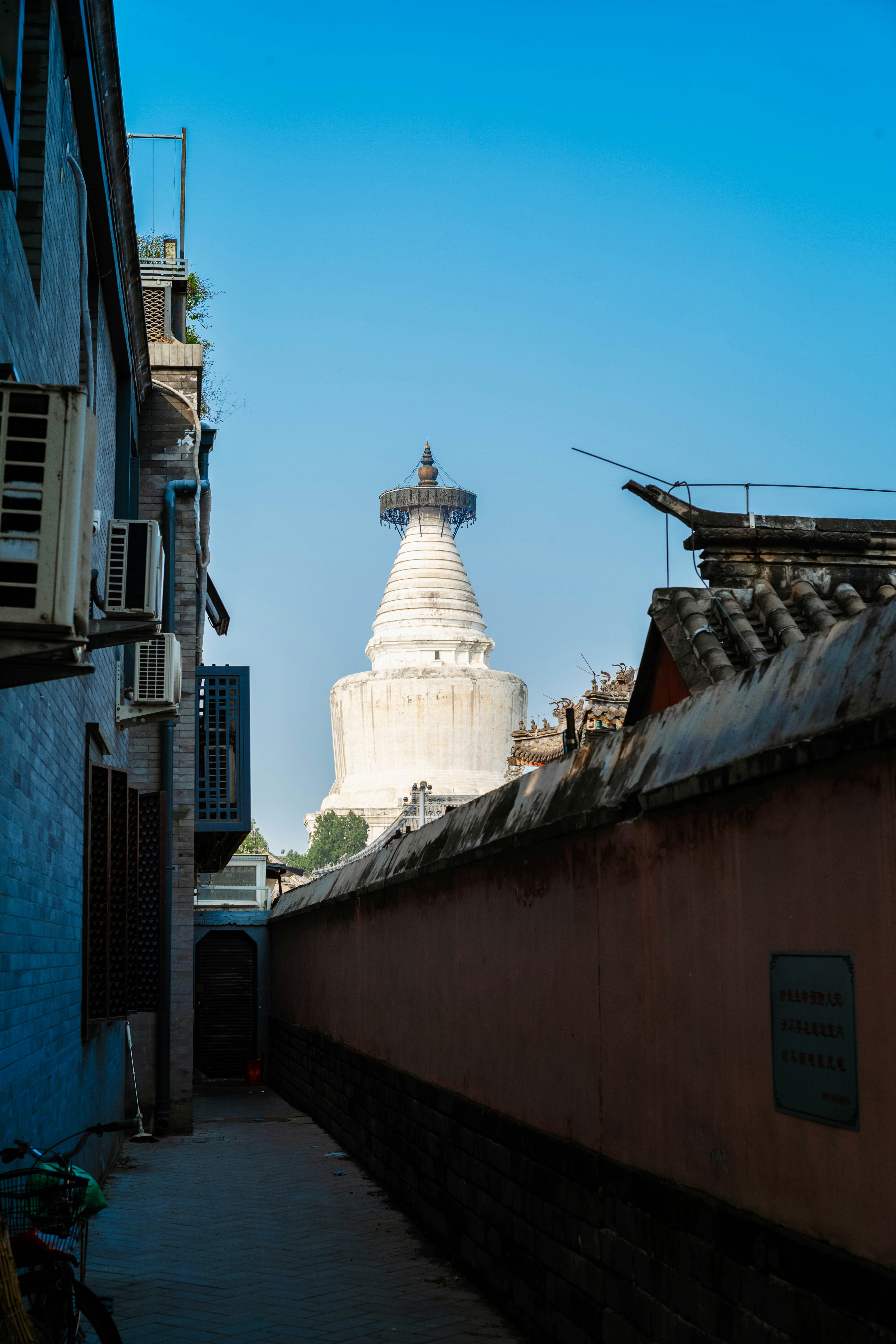 Alley Convergence: The White Stupa Framed by Time-Worn Walls